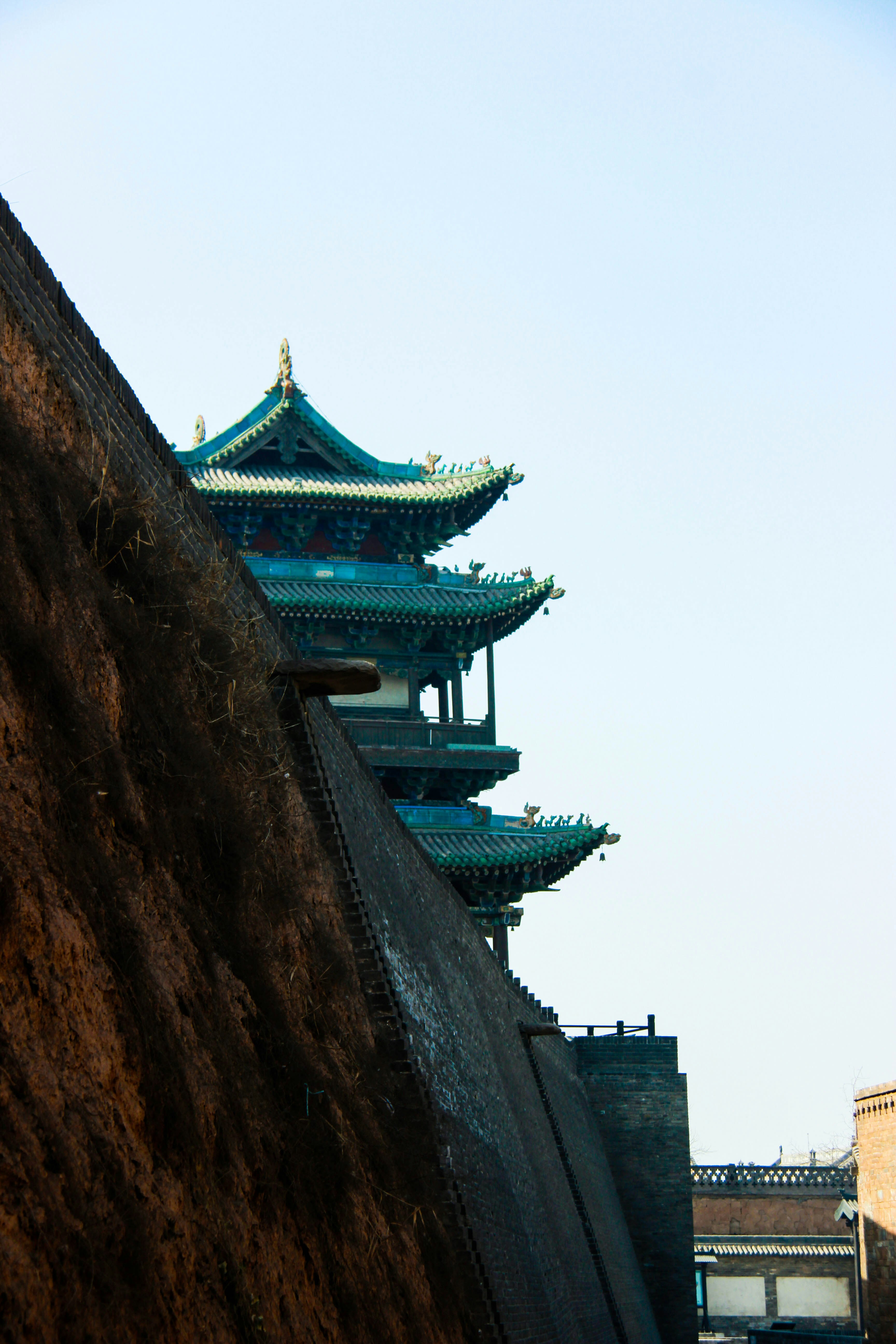 Ancient Pagoda Piercing the Skyline beside a Weathered Rampart