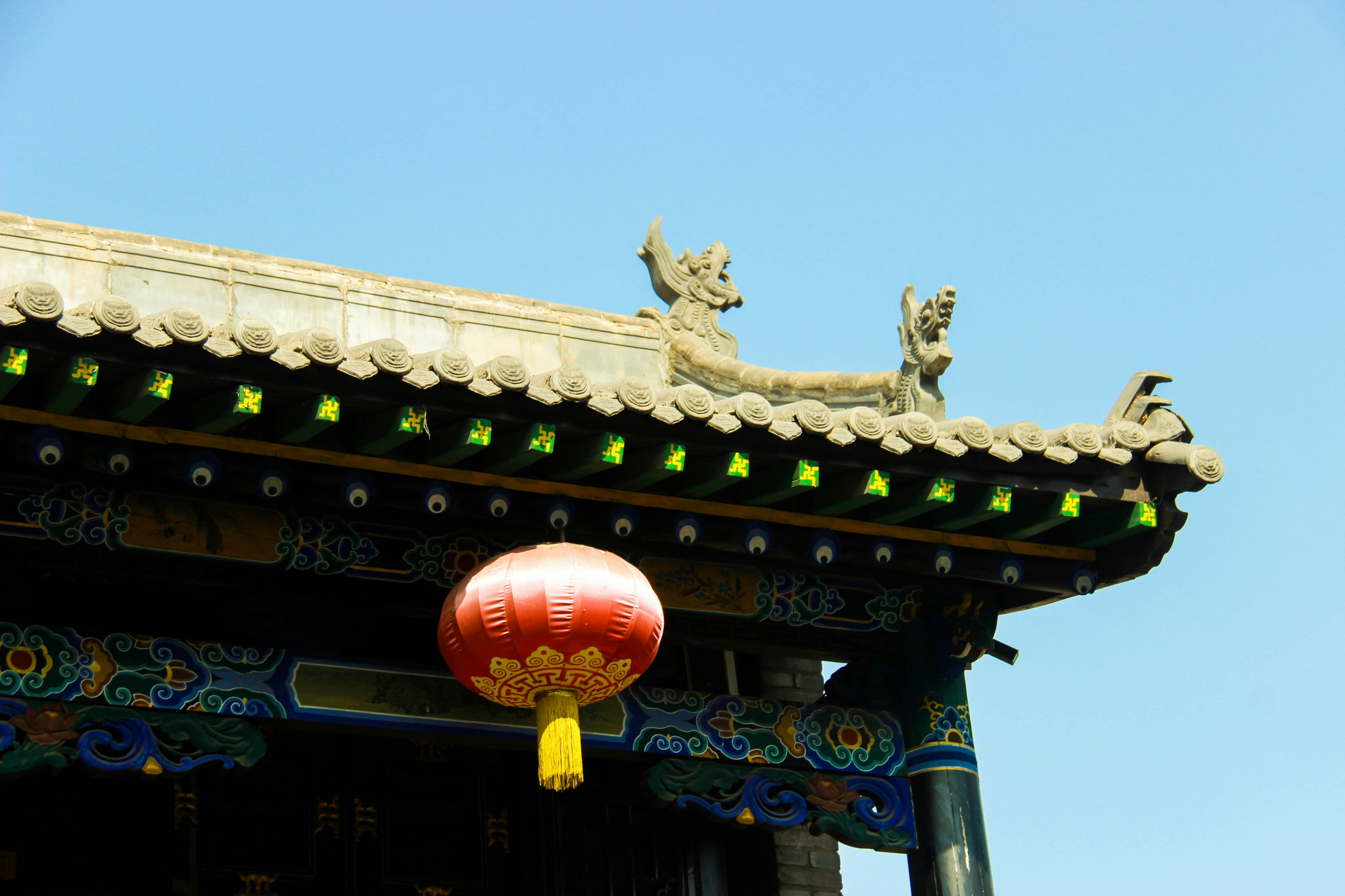 Red Lantern Adornments Under a Carved Rooftop Overhang