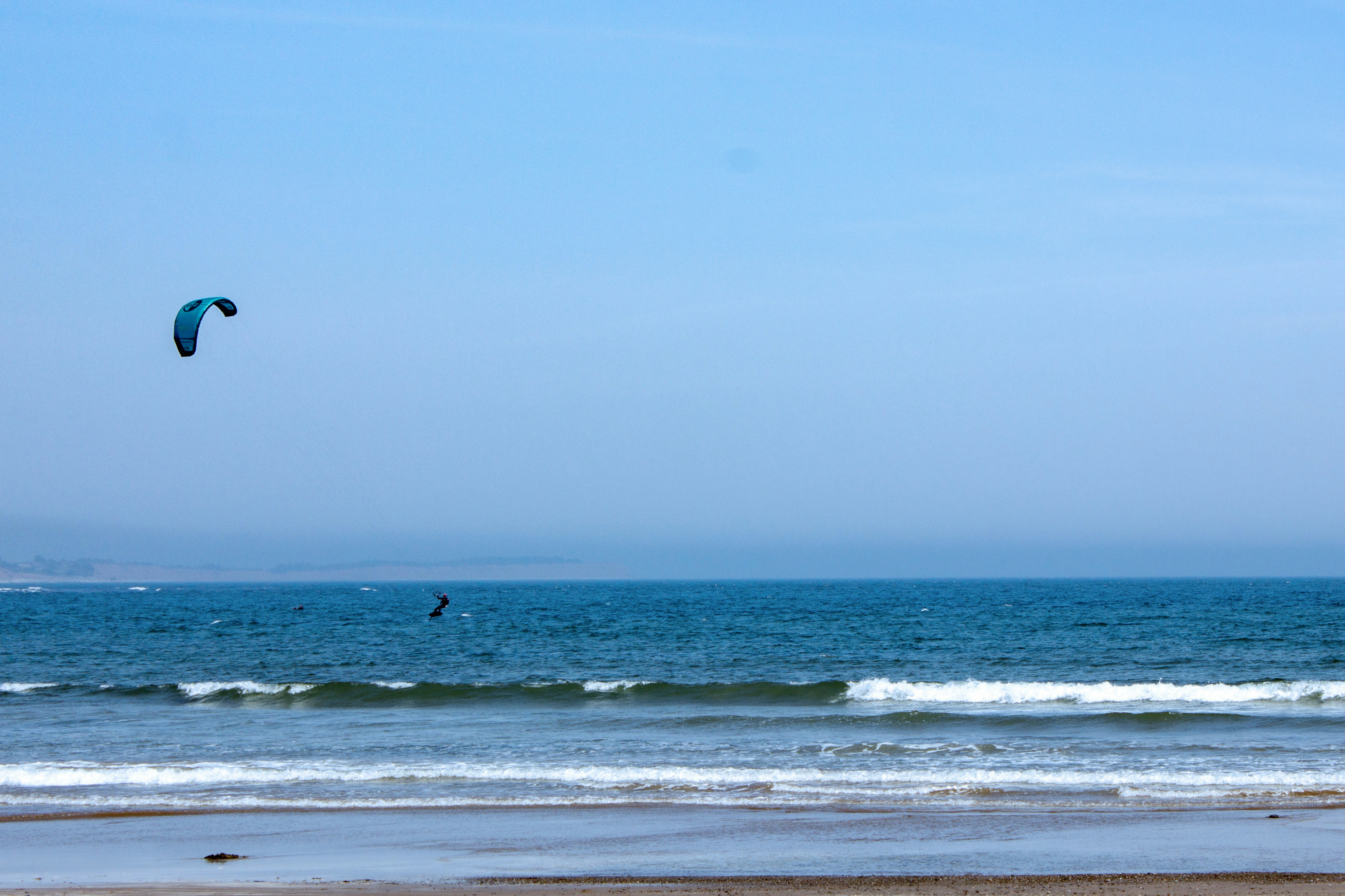 Kite Surfer Silhouette on a Calm Coastal Horizon