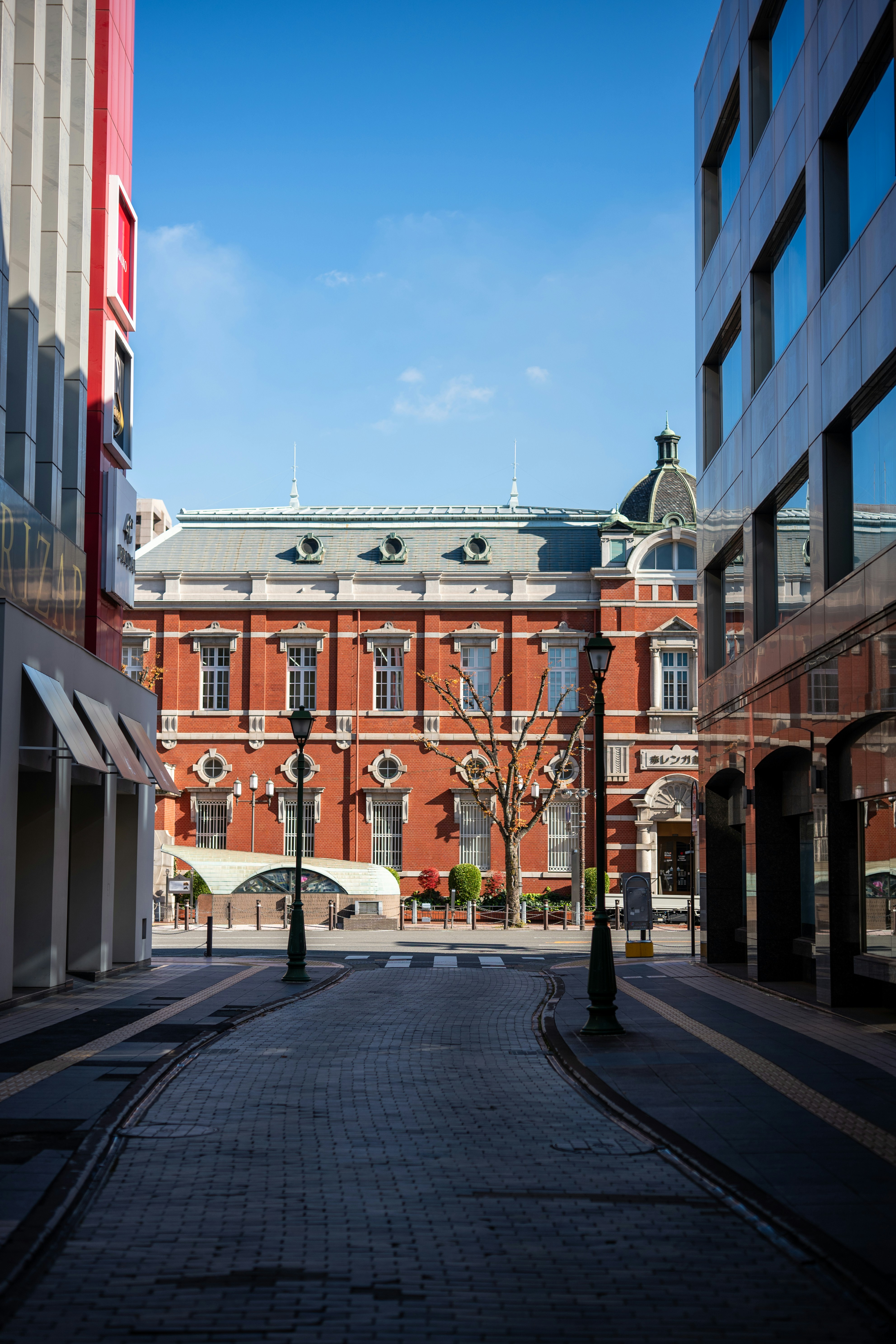 Through the City Corridor: A Red Brick Facade Framed by Modern Arcades