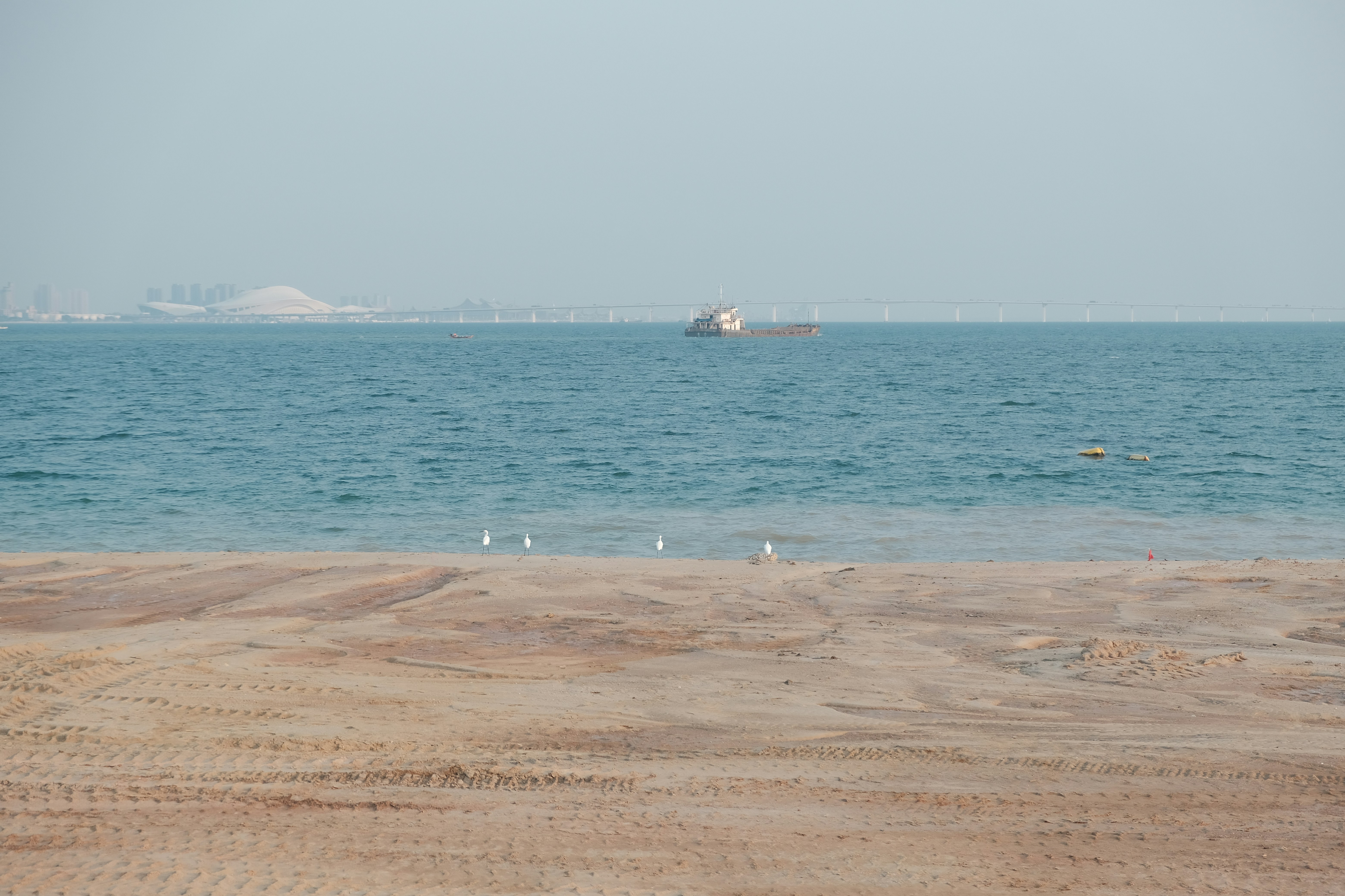 Calm Coastal Line: Dune, Sea, and Distant Barge