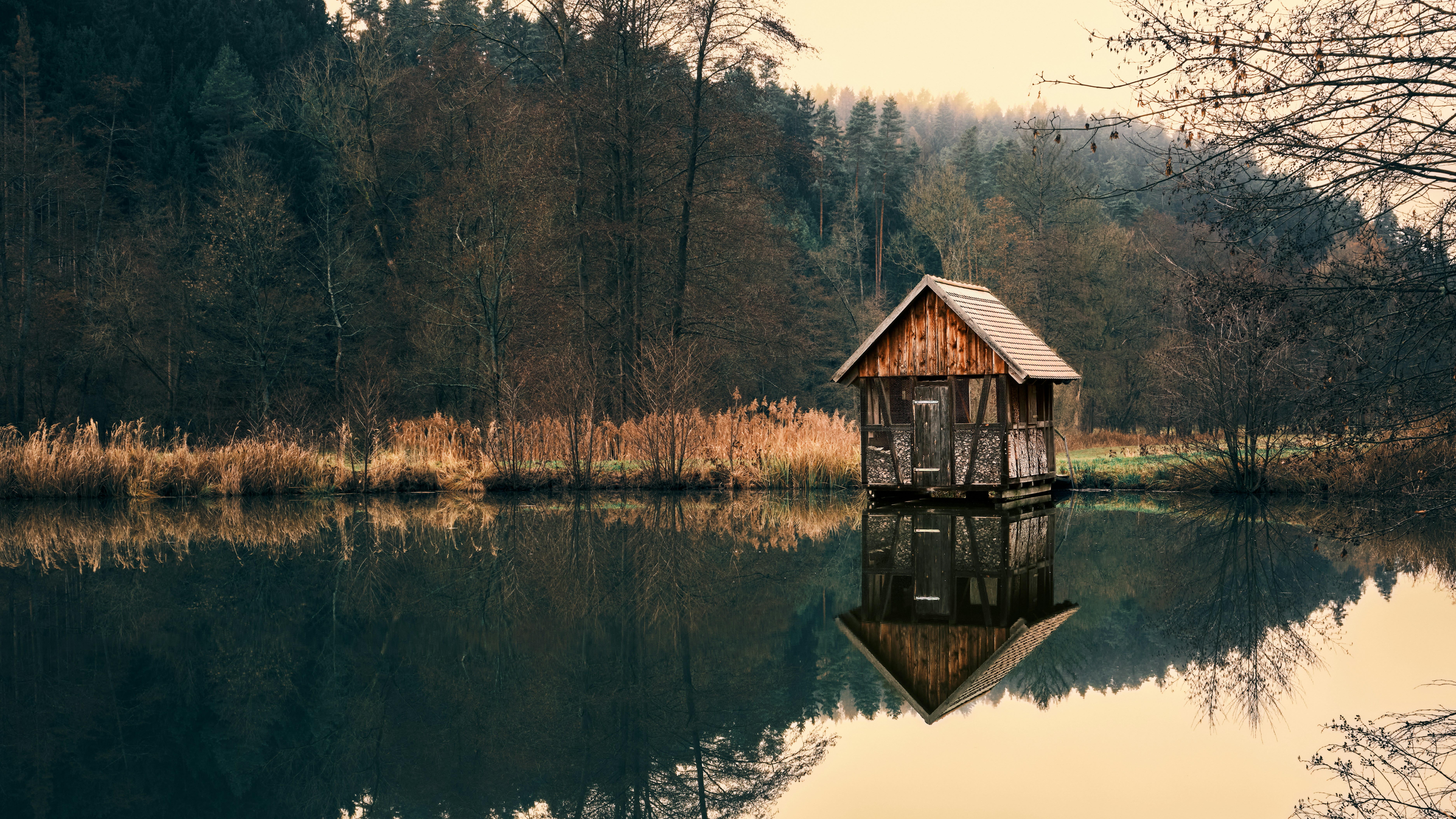 Wooden boathouse cradle of still water at dusk