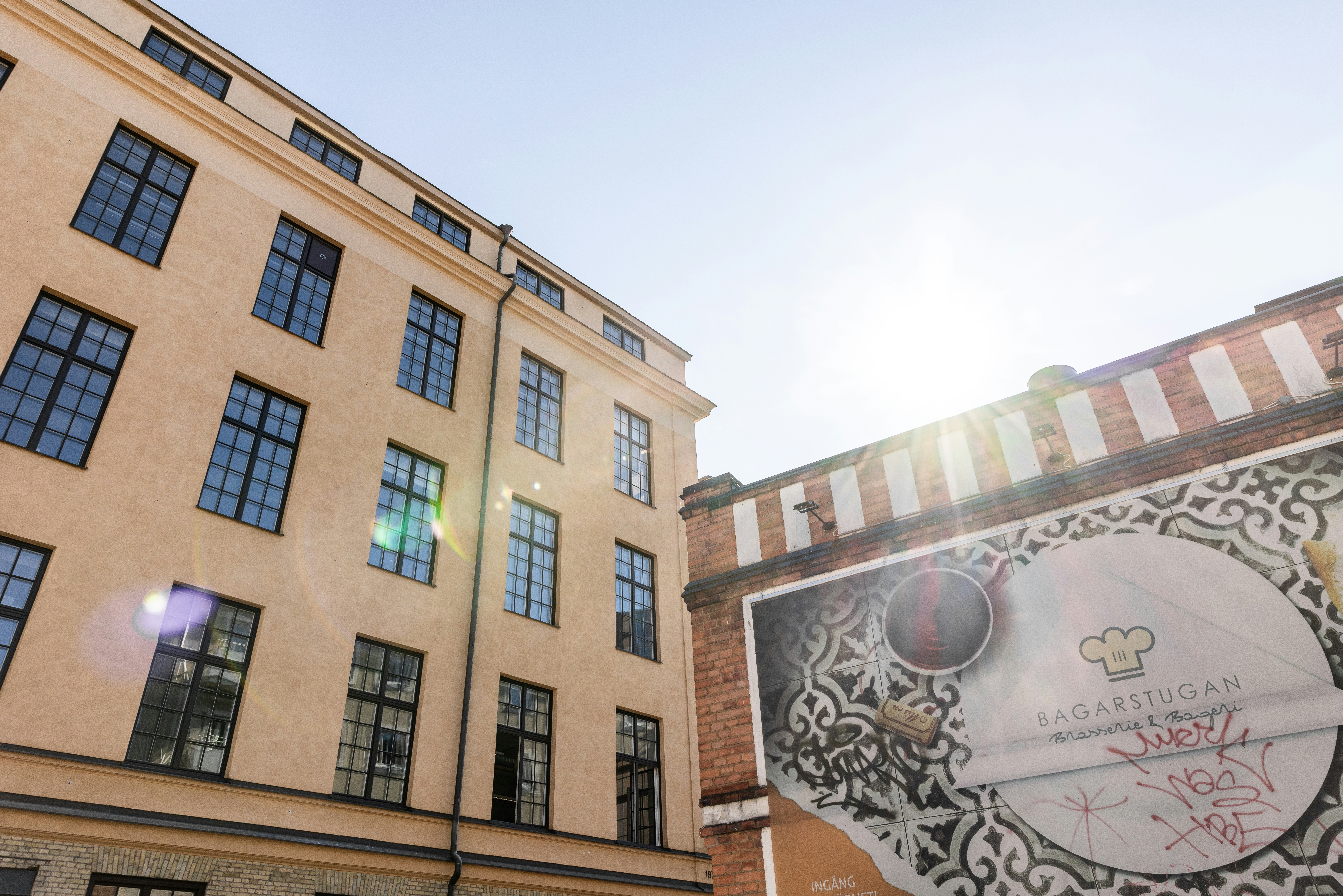 Sunlit Brick Facades and a Decorative Mural Catch the Eye at Street Level
