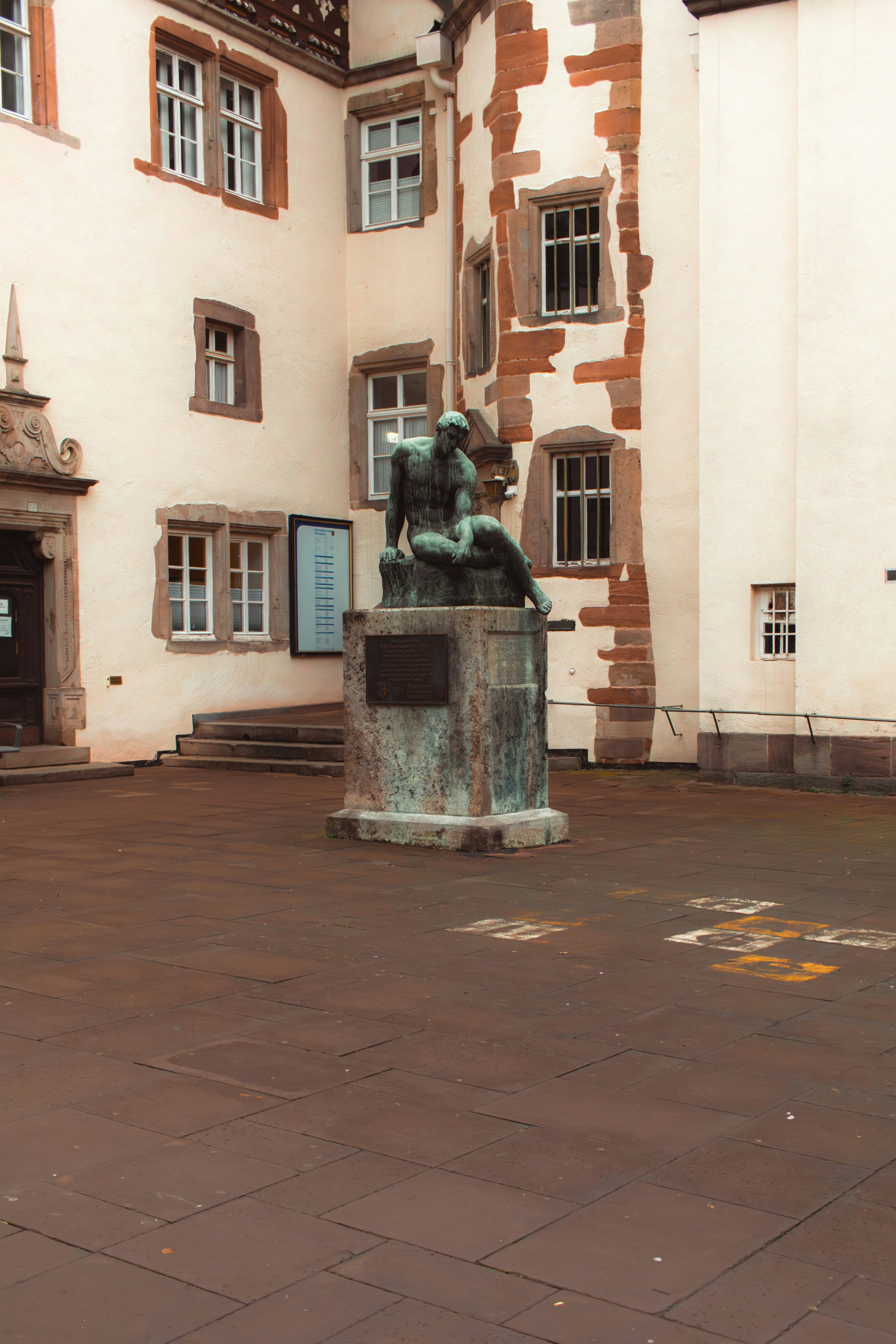 Bronze Thinker on a Stone Pedestal Guarding a Quiet Courtyard