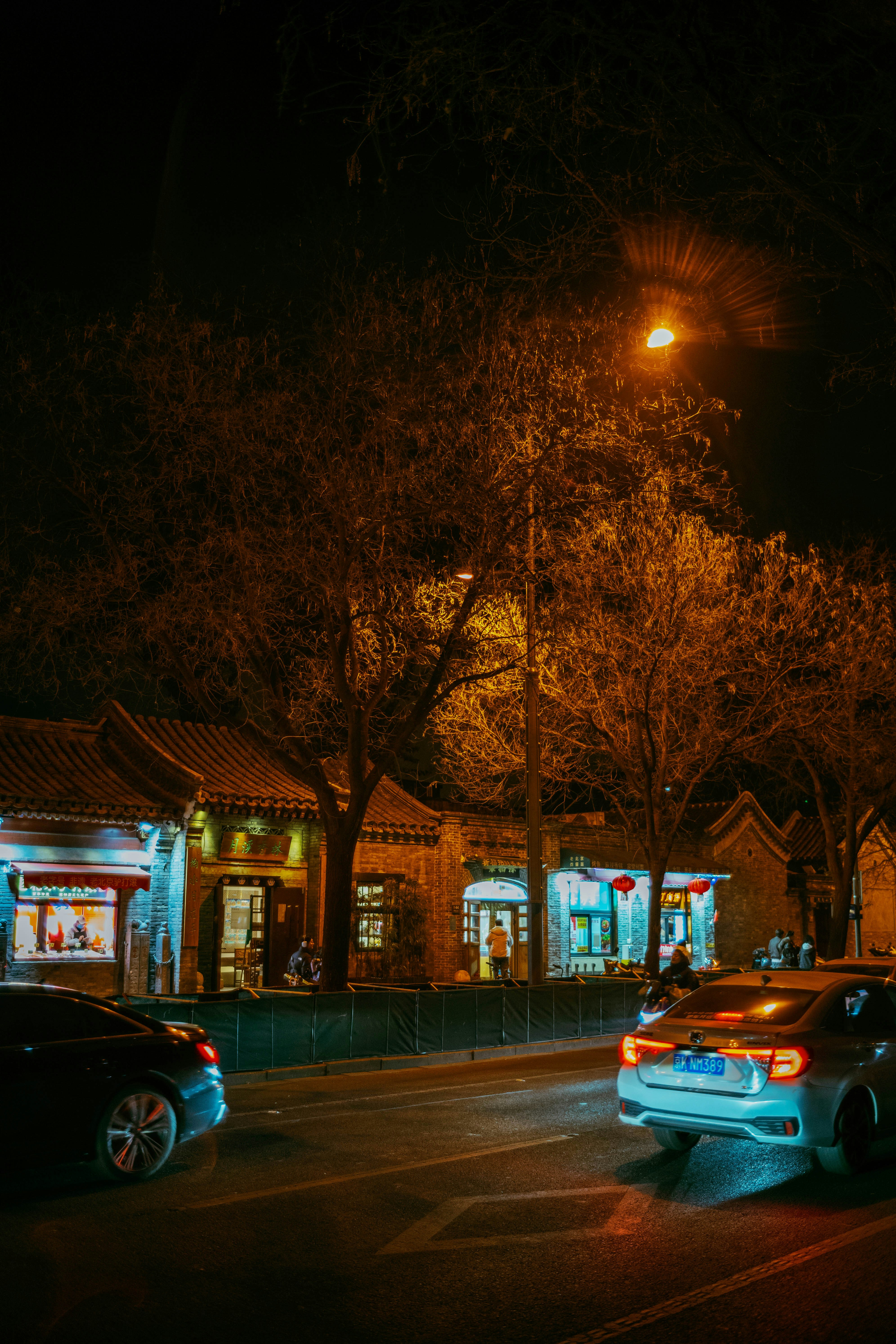 Nighttime Street Lanterns illuminate a bustling riverside doorway row