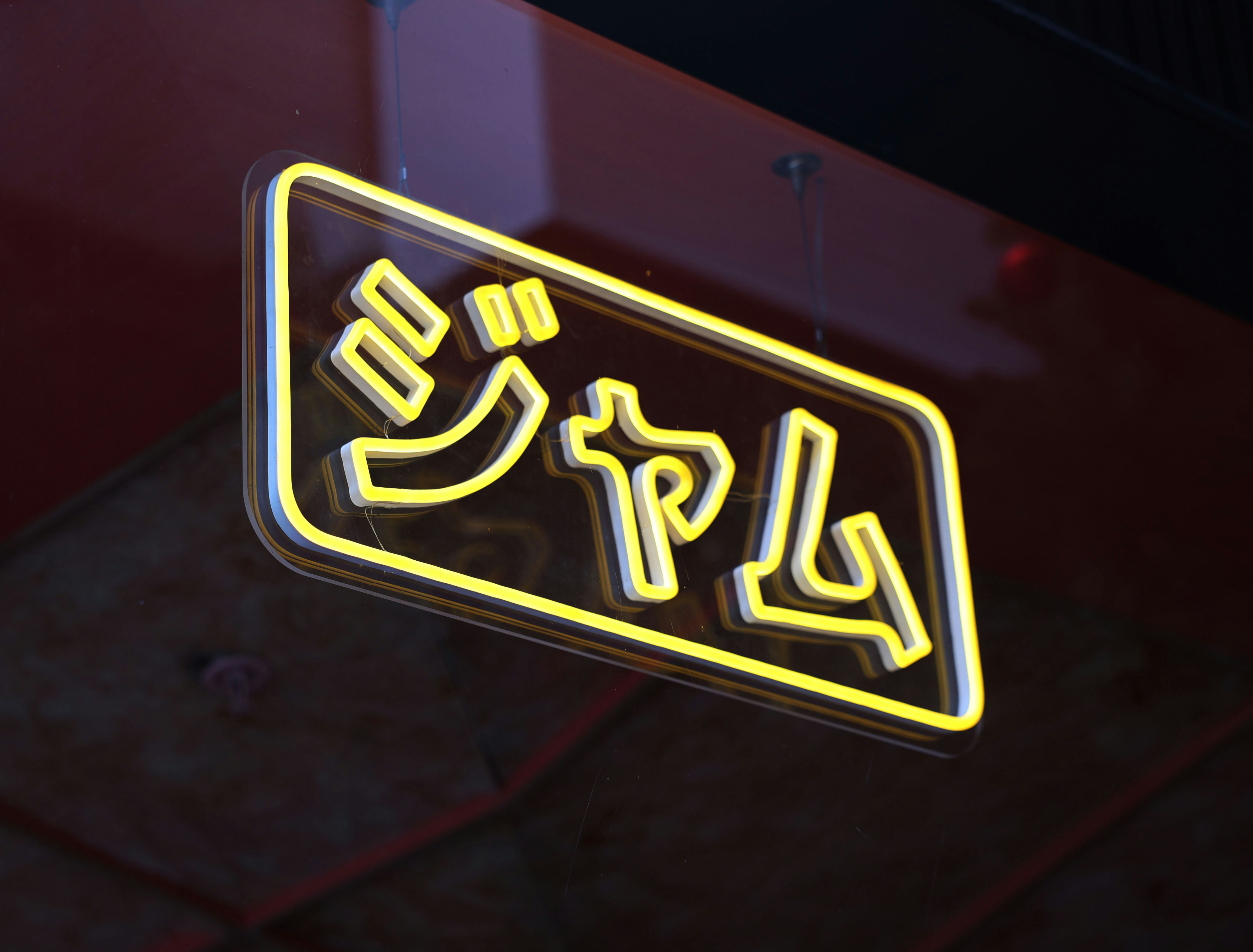 Neon Sign in the Night: Japanese Characters Glow Over Dark Facade