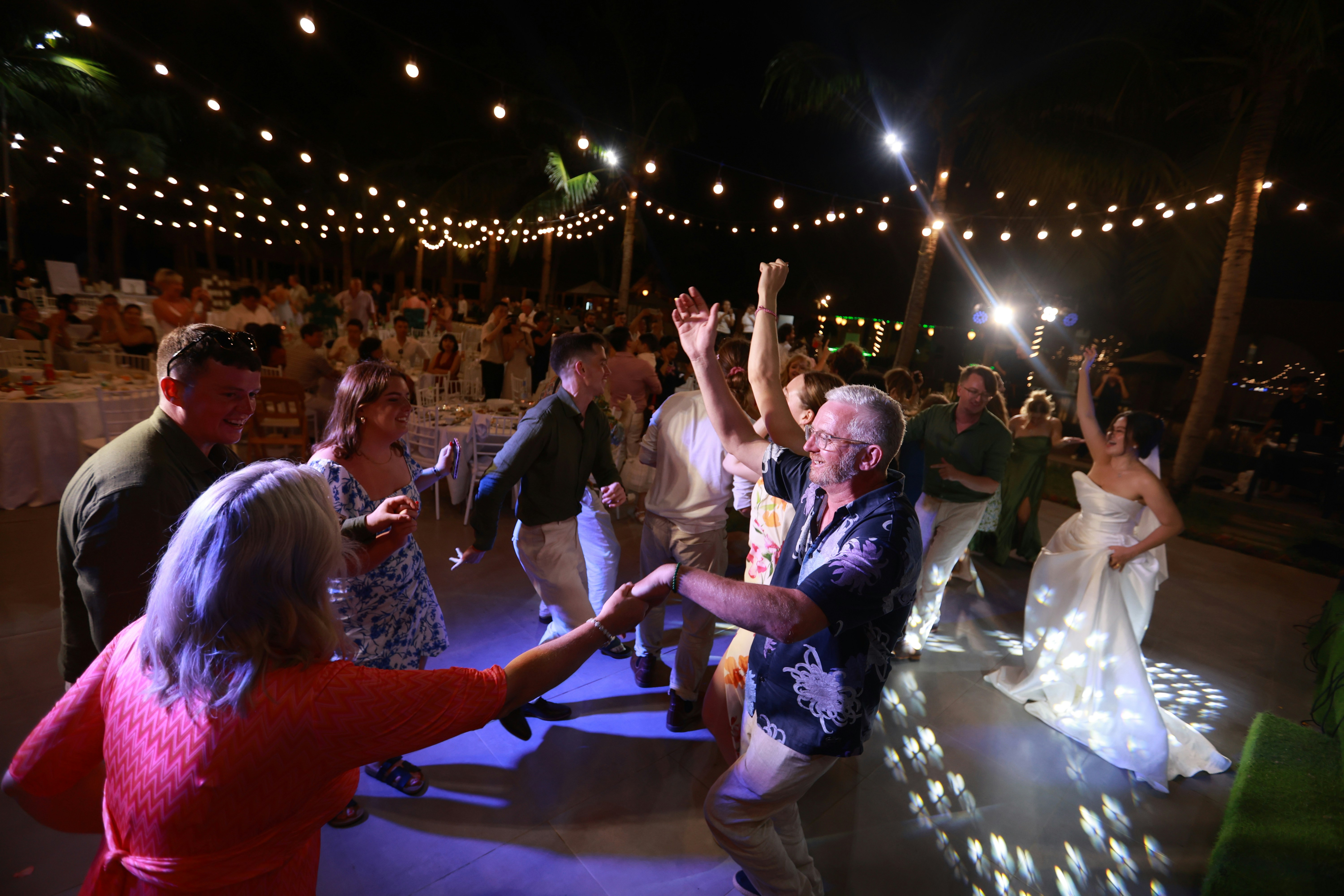 People dancing at an outdoor night party with string lights. photo ...