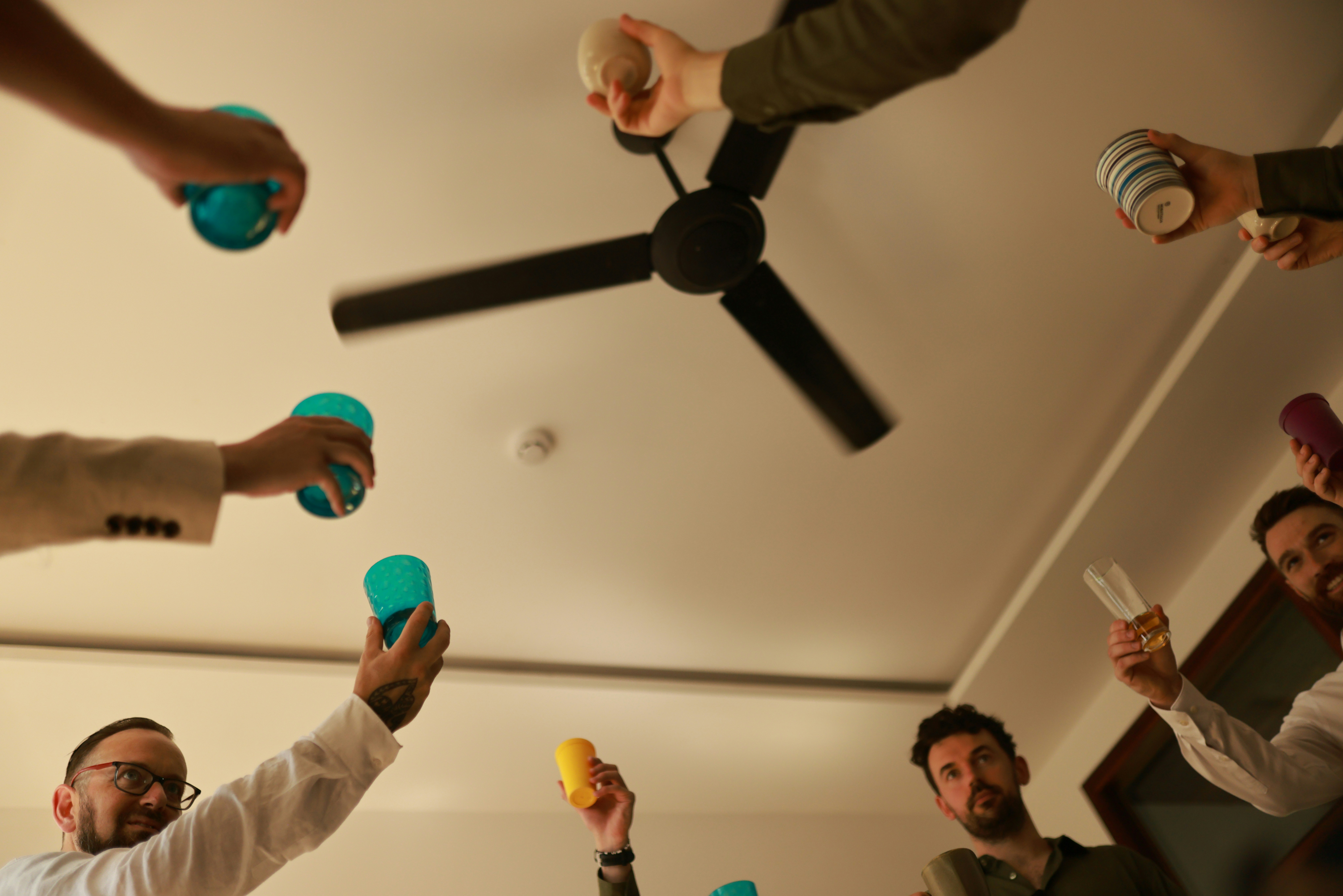 Upbeat Toast: Group cheers under a ceiling fan