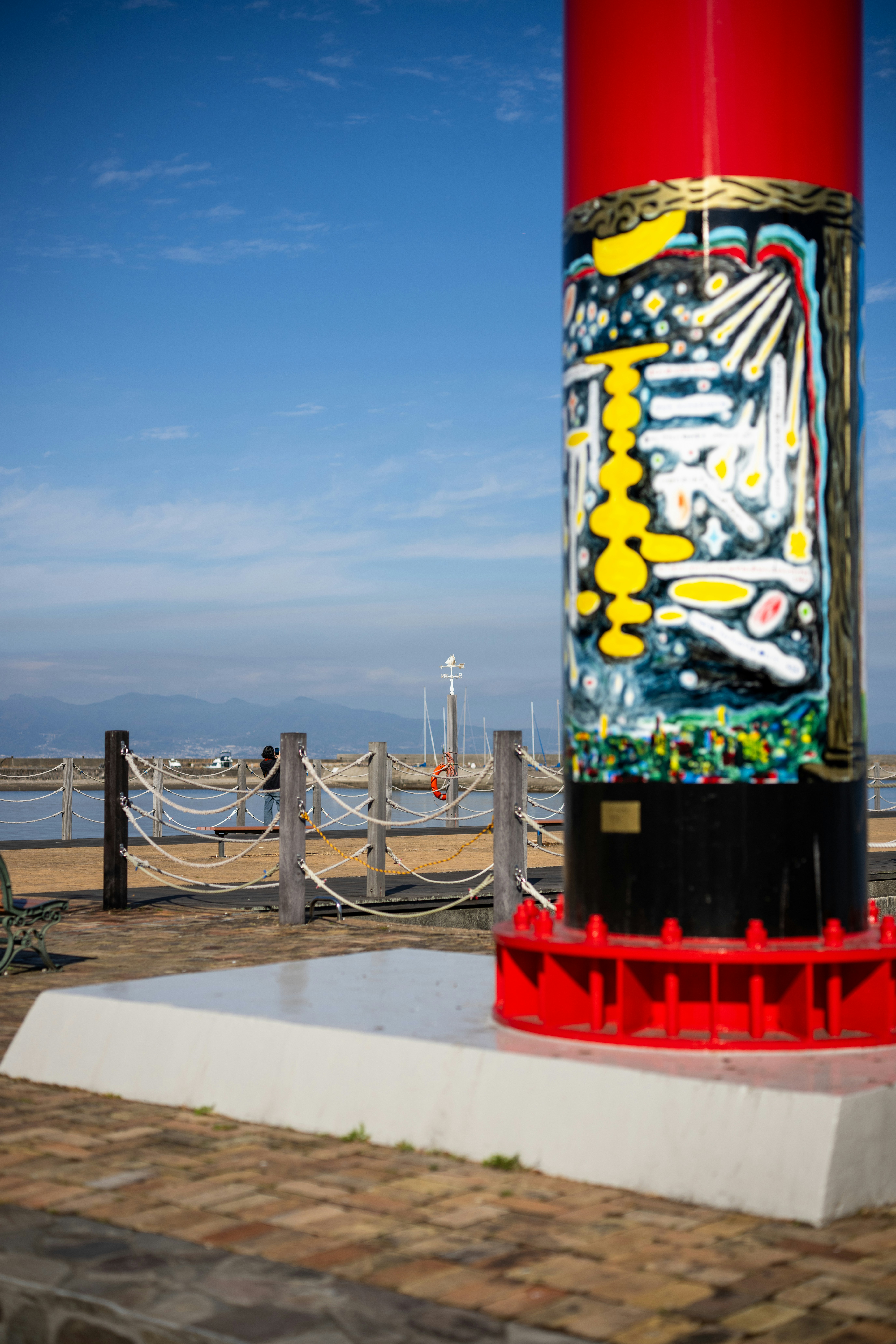 Red Column, Painted Tale: A Pier-Side Portrait with a Splashed Mural