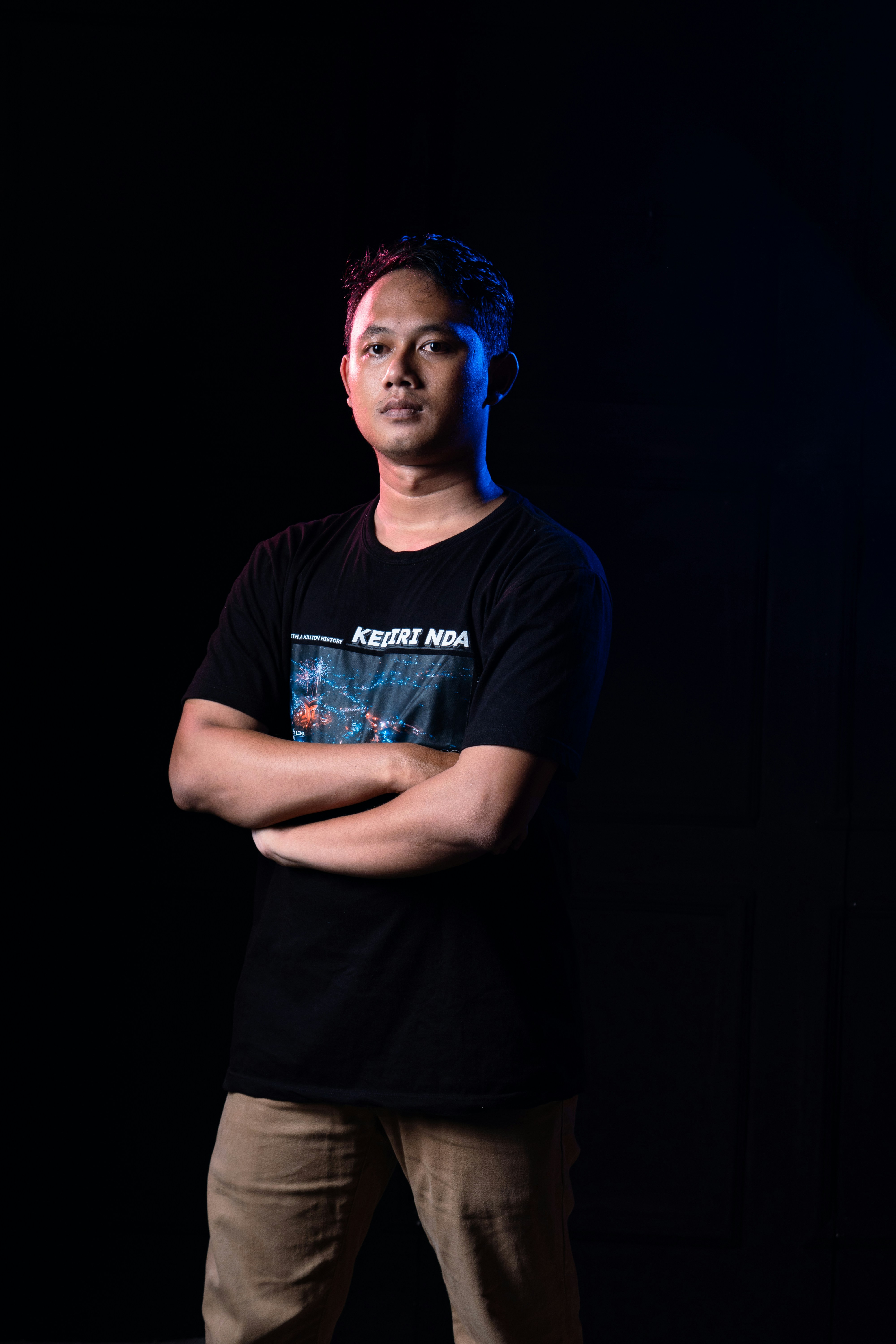 Crossed Arms, Quiet Confidence: A Portrait in Dim Studio Light