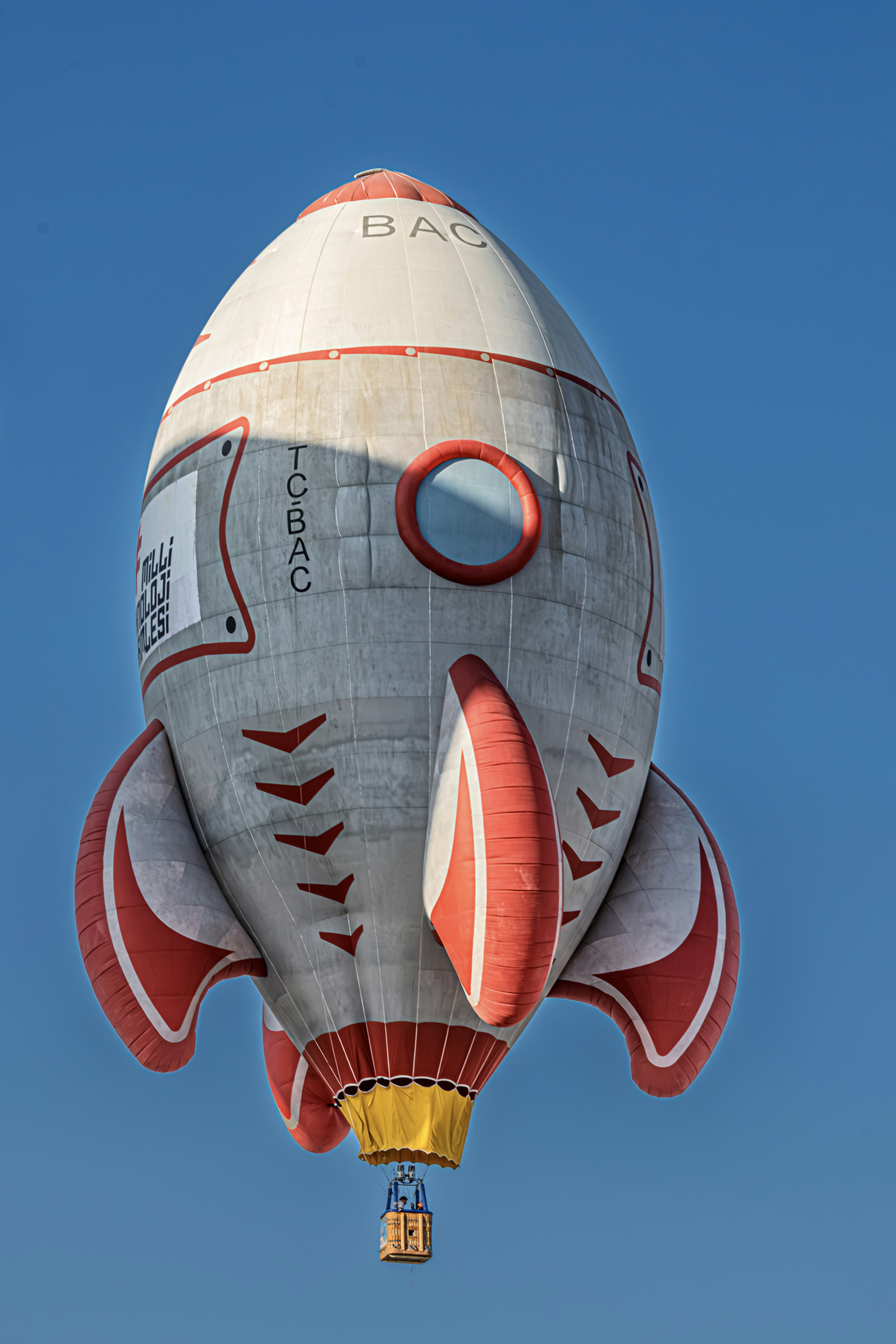 Rocket Ship in the Sky: A Red-White Balloon Lifted by a Tiny Basket