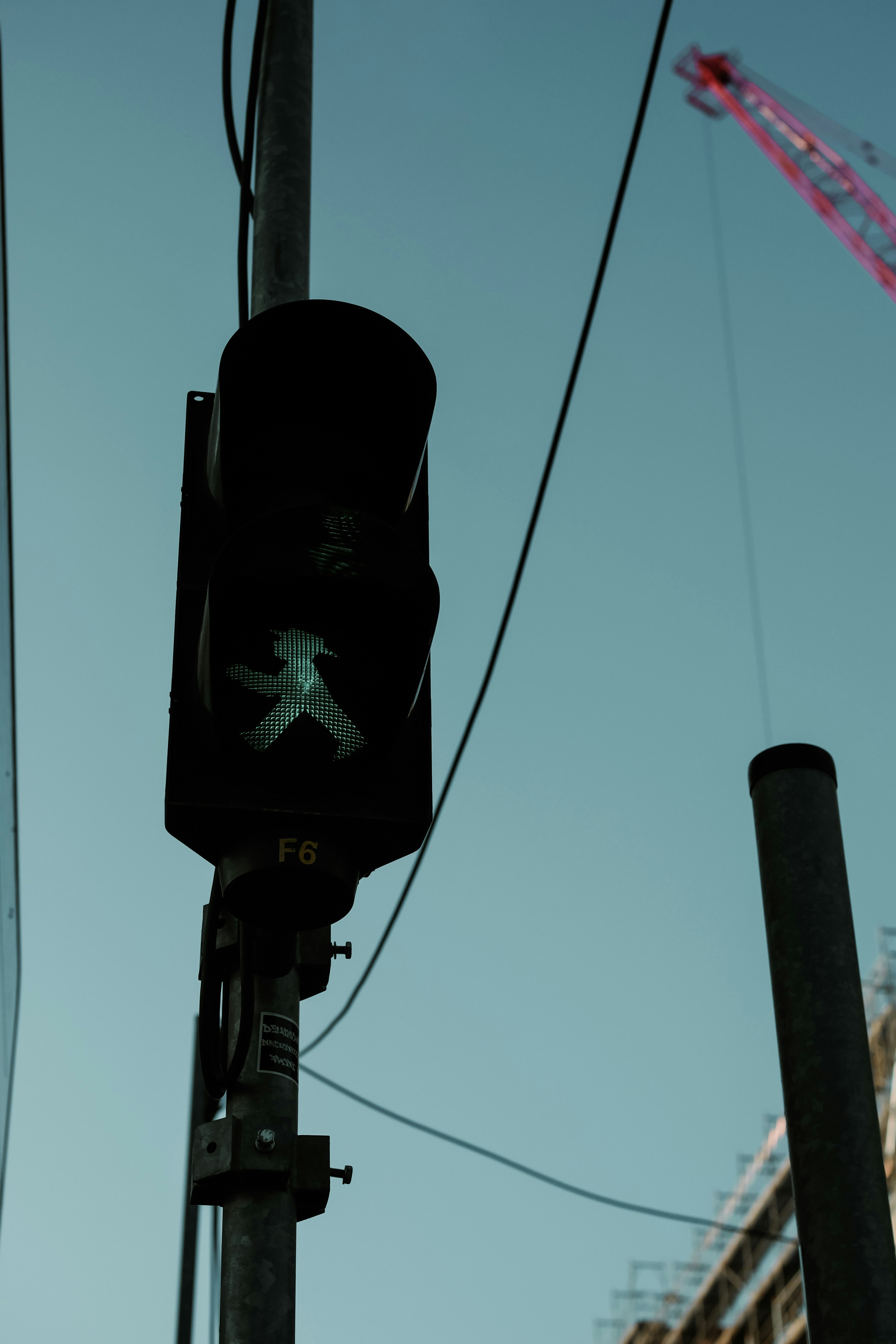 Waiting Signal: A Pedestrian Crossing with a Crane in the Distance