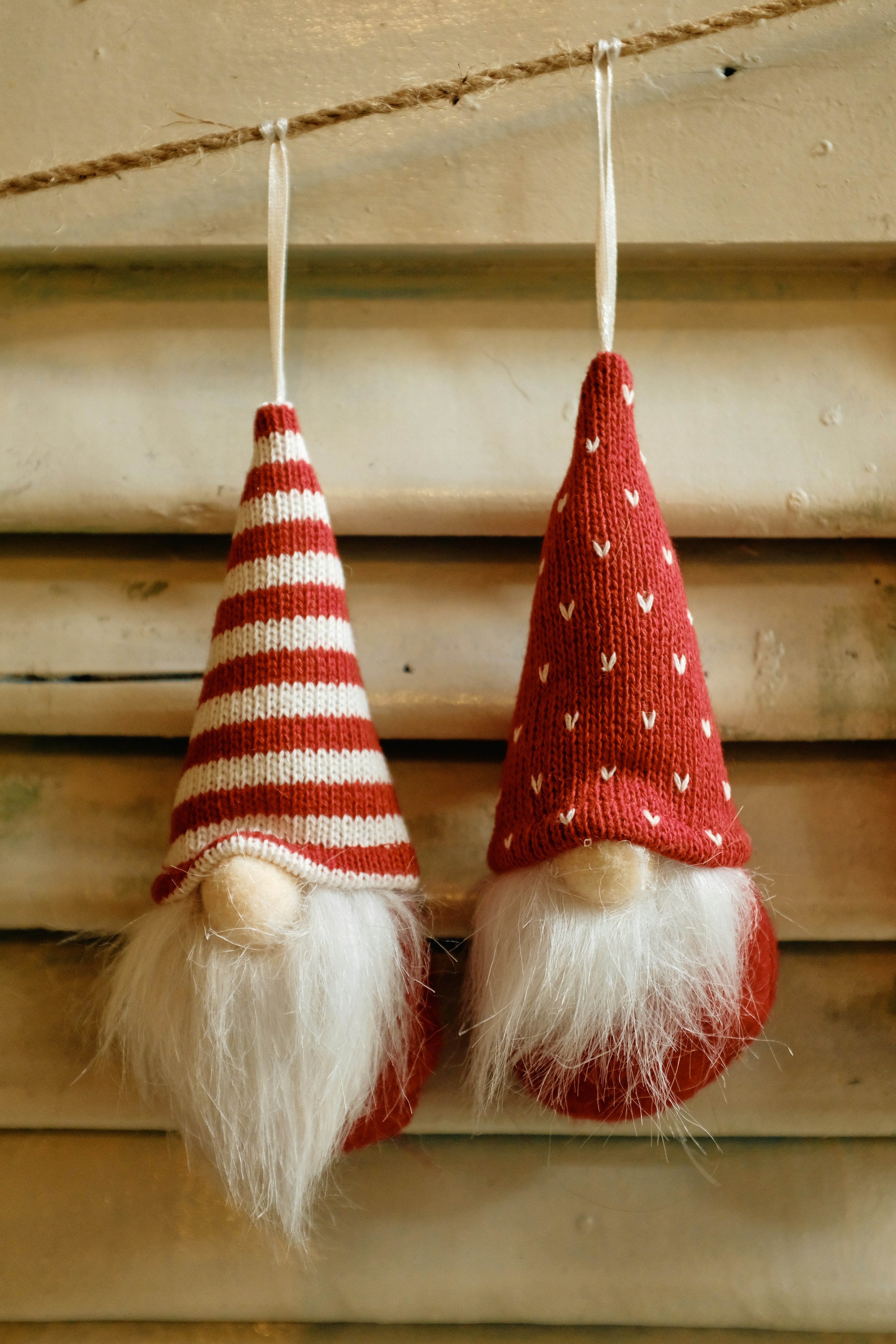 Twin Santa: Striped and Heart-dotted Hats Hanging in Quiet Light