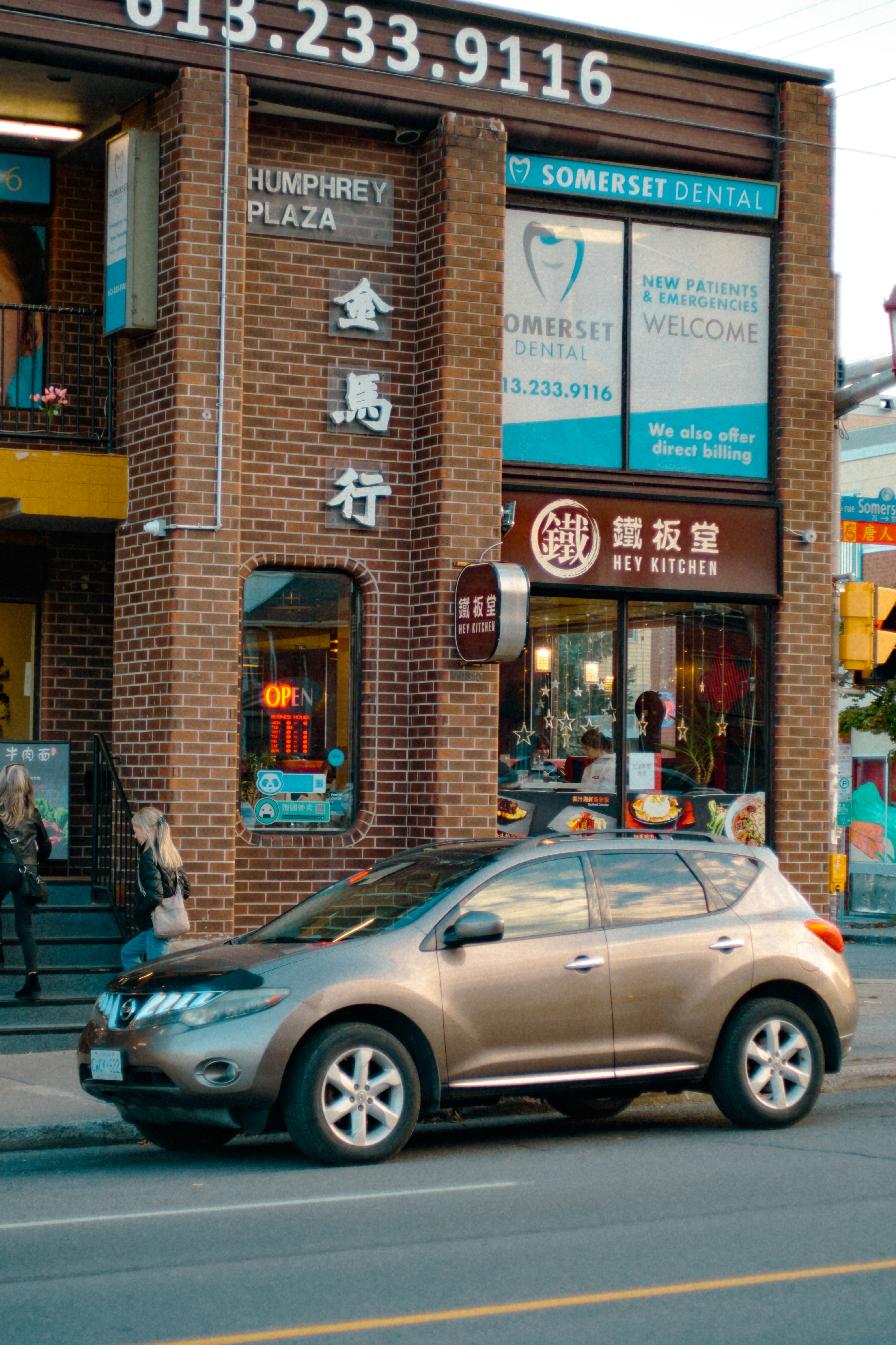 Brick Facades and a Silver SUV: City Street at Humfrey Plaza