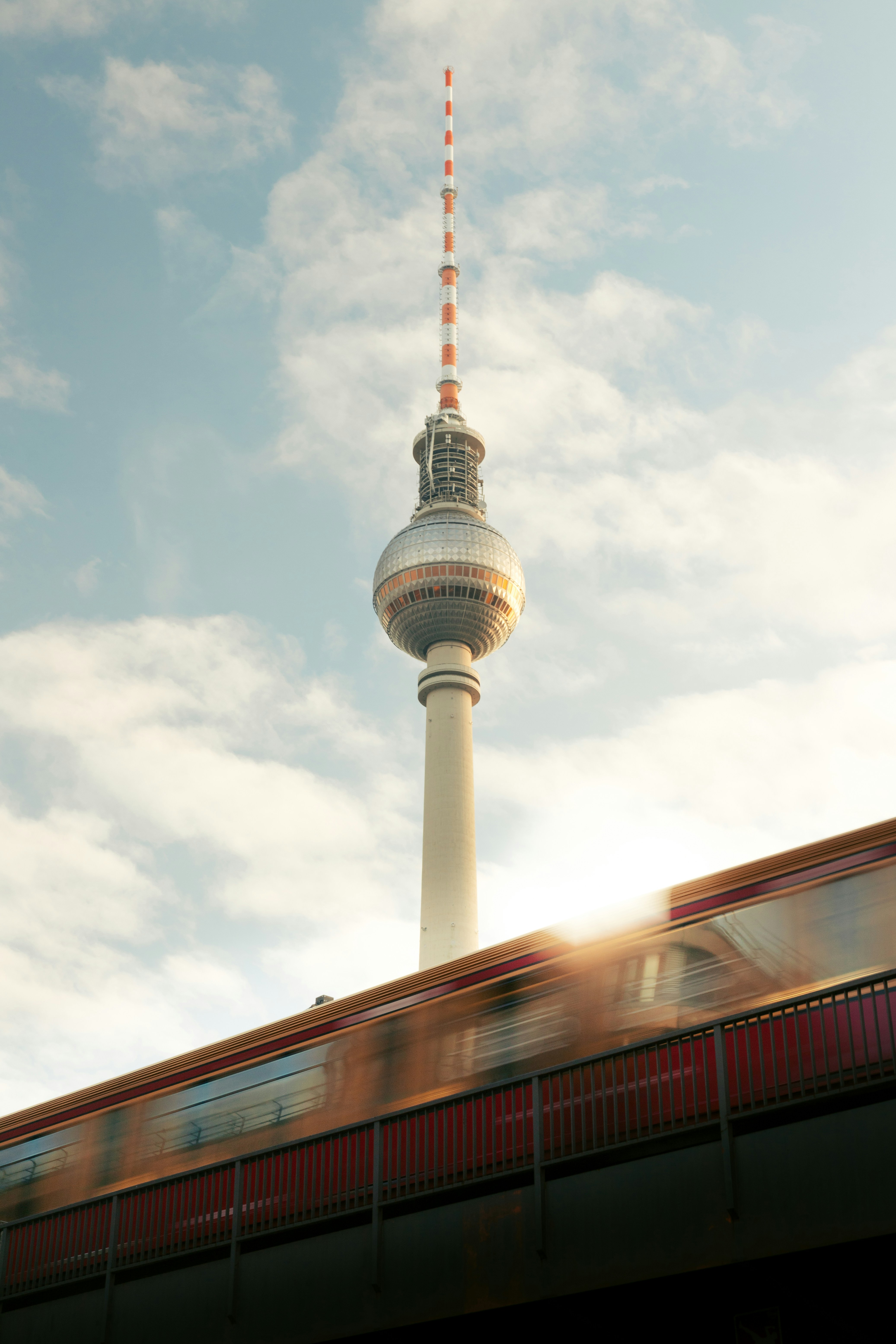 Telecom Tower Ascendant: A Train Slicing Under a Sky-Blue Noon