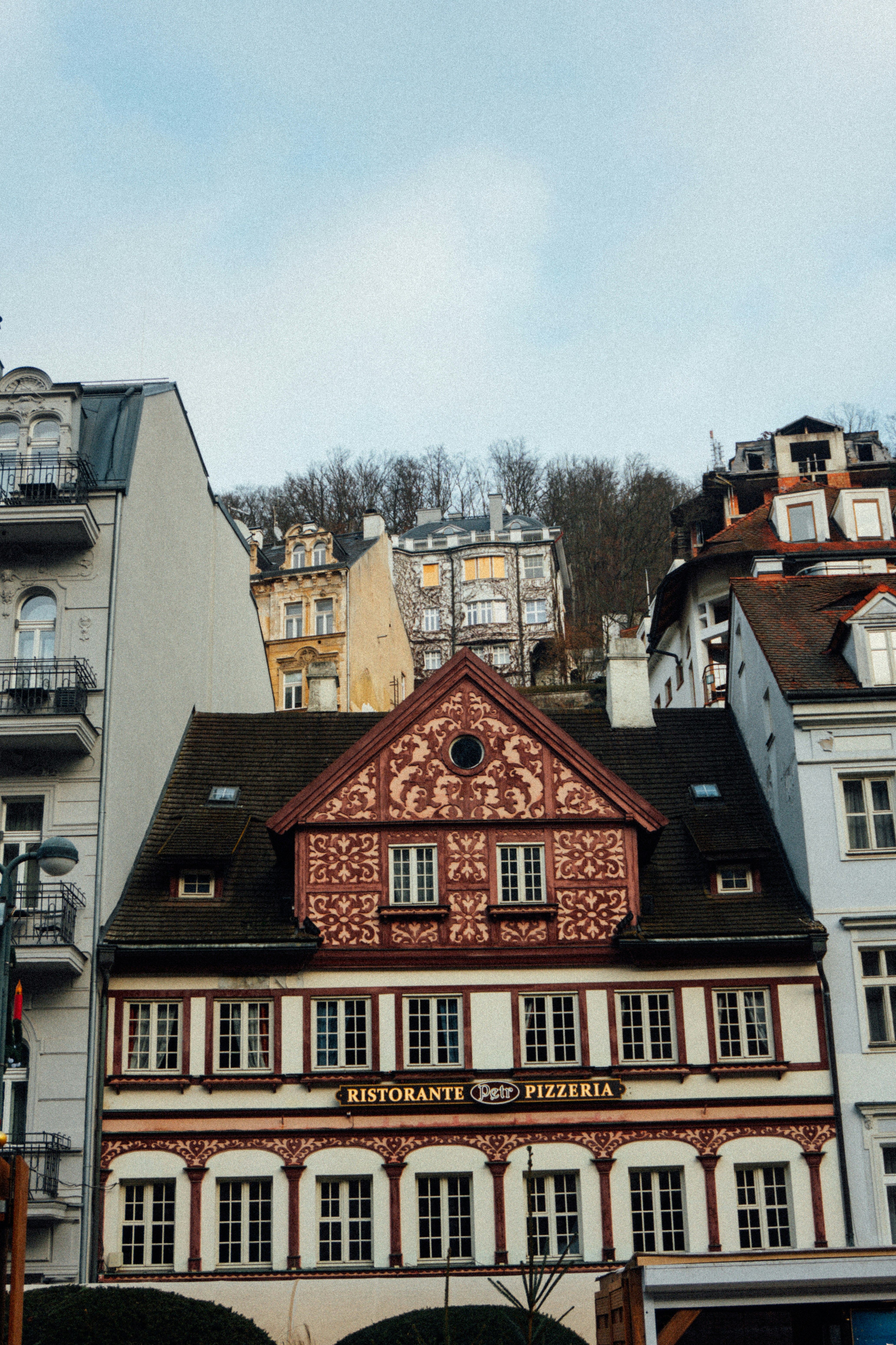 Historic Pizzeria Facade Framed by City Rooftops