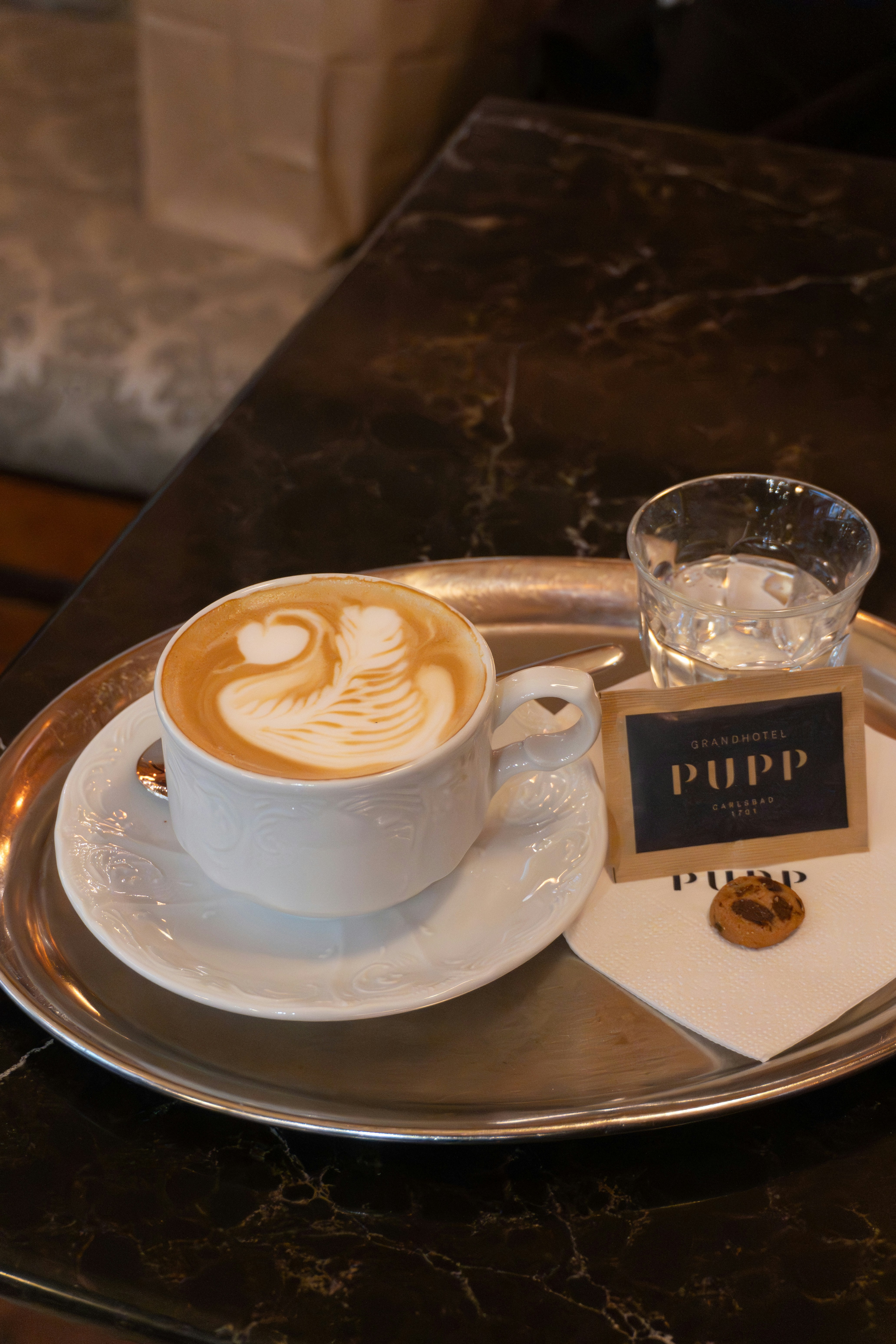 Elegant Flat White on a Shiny Tray with a PTP Card and Cookie