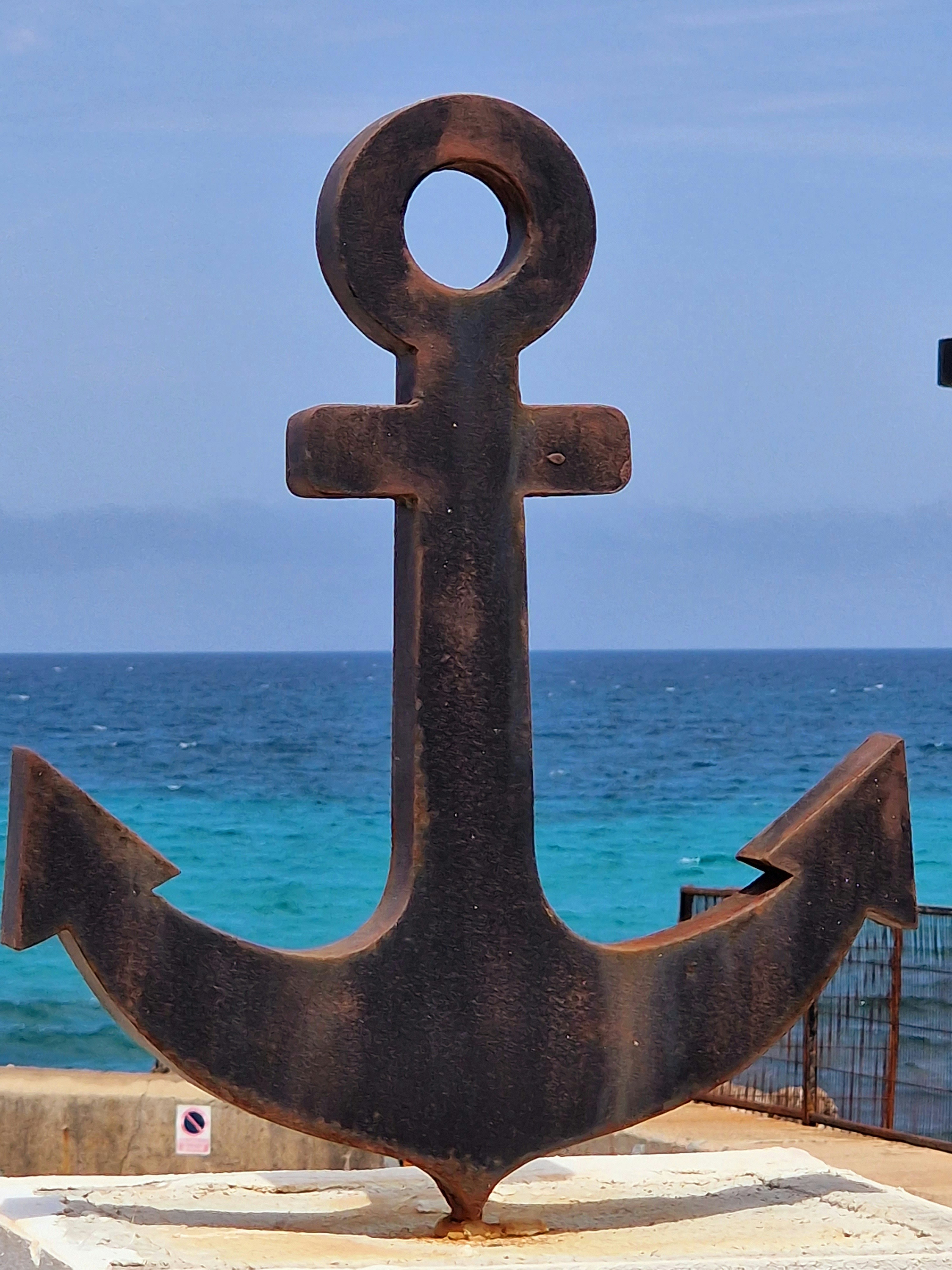 Anchor at the Edge of Sea: A Weathered Statue of Strength