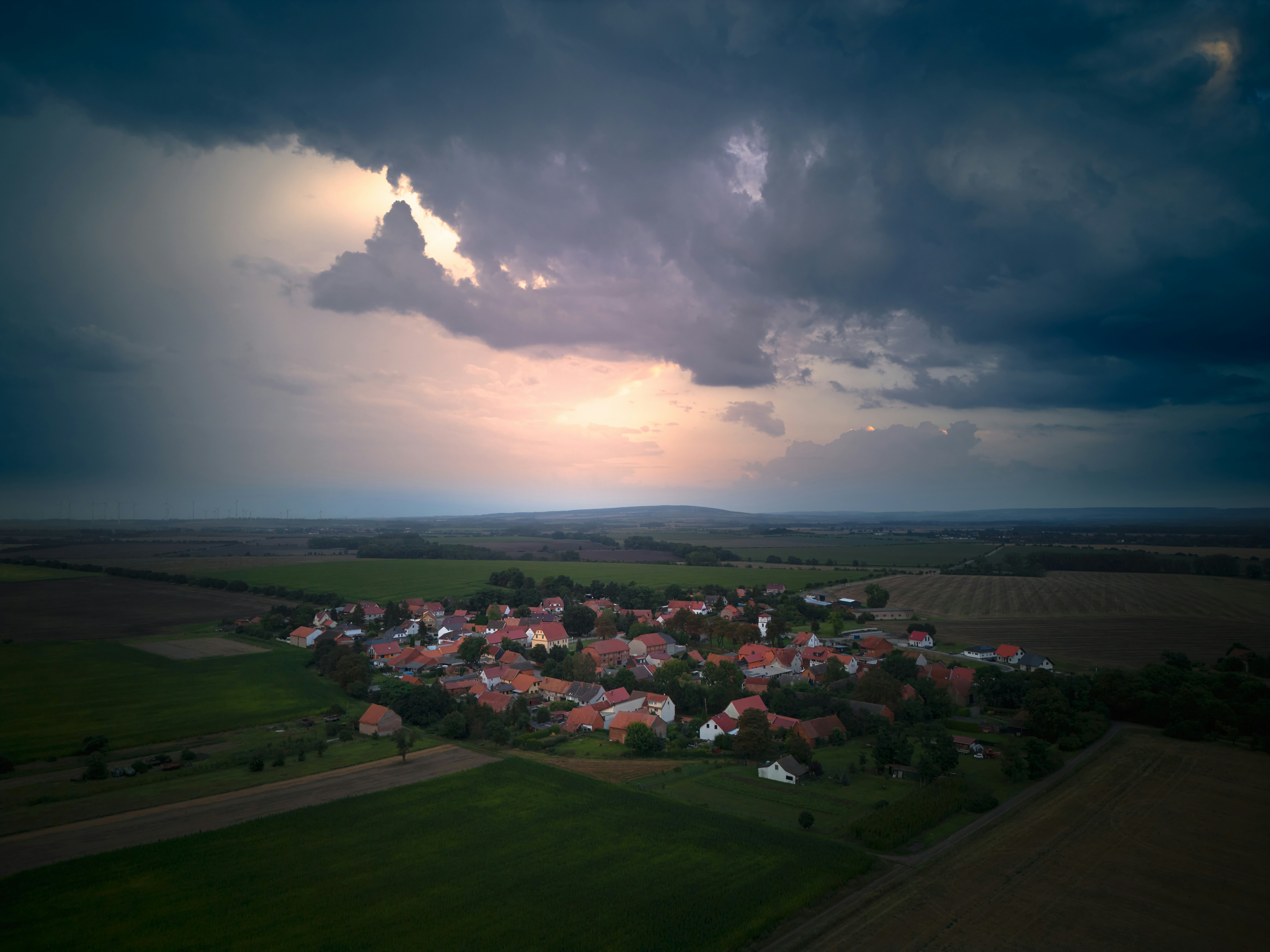 Storm Over the Village: A Quiet Horizon Under Cloudburst Light
