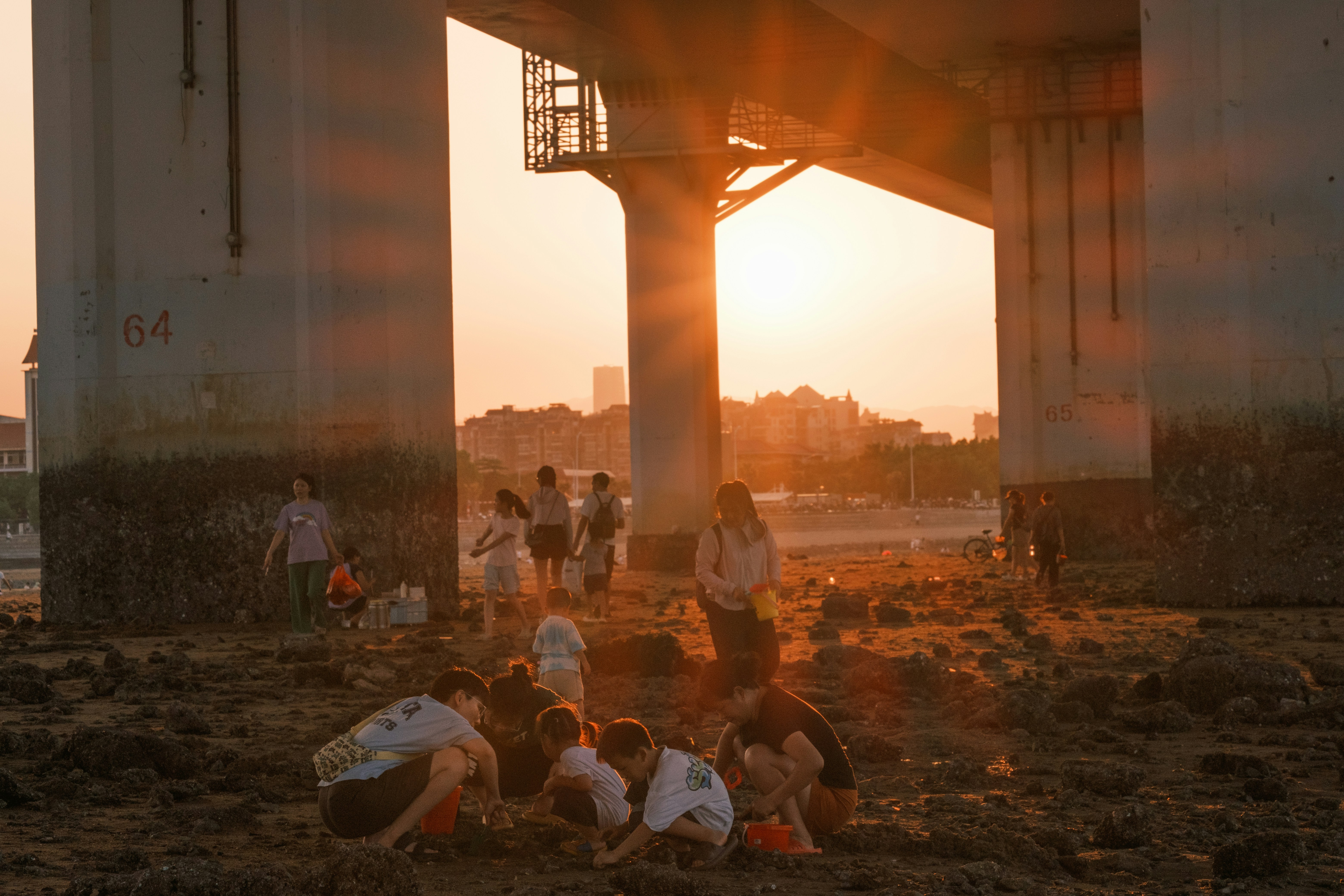 Sunlit Underpass: Children Gather in a Quiet Riverside Afterglow