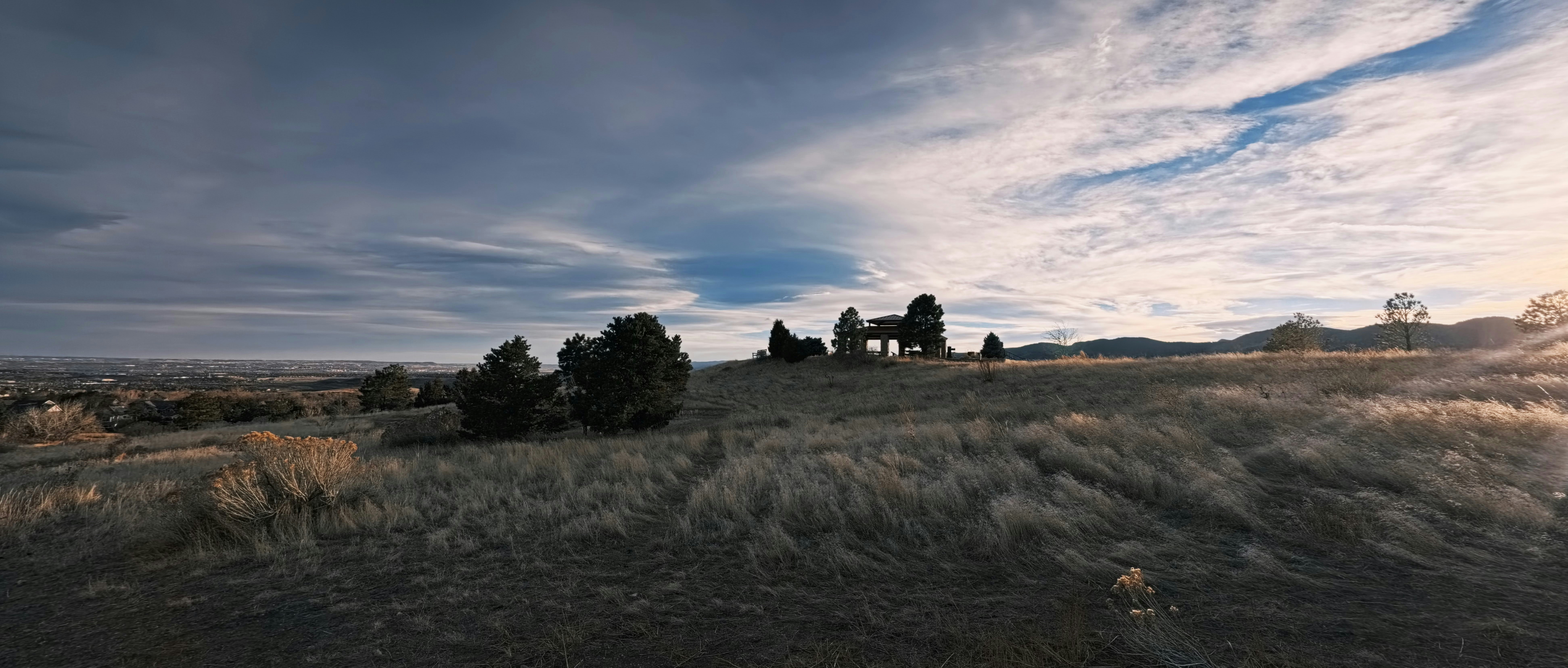Ruins on a grassy hill under a cloudy sky