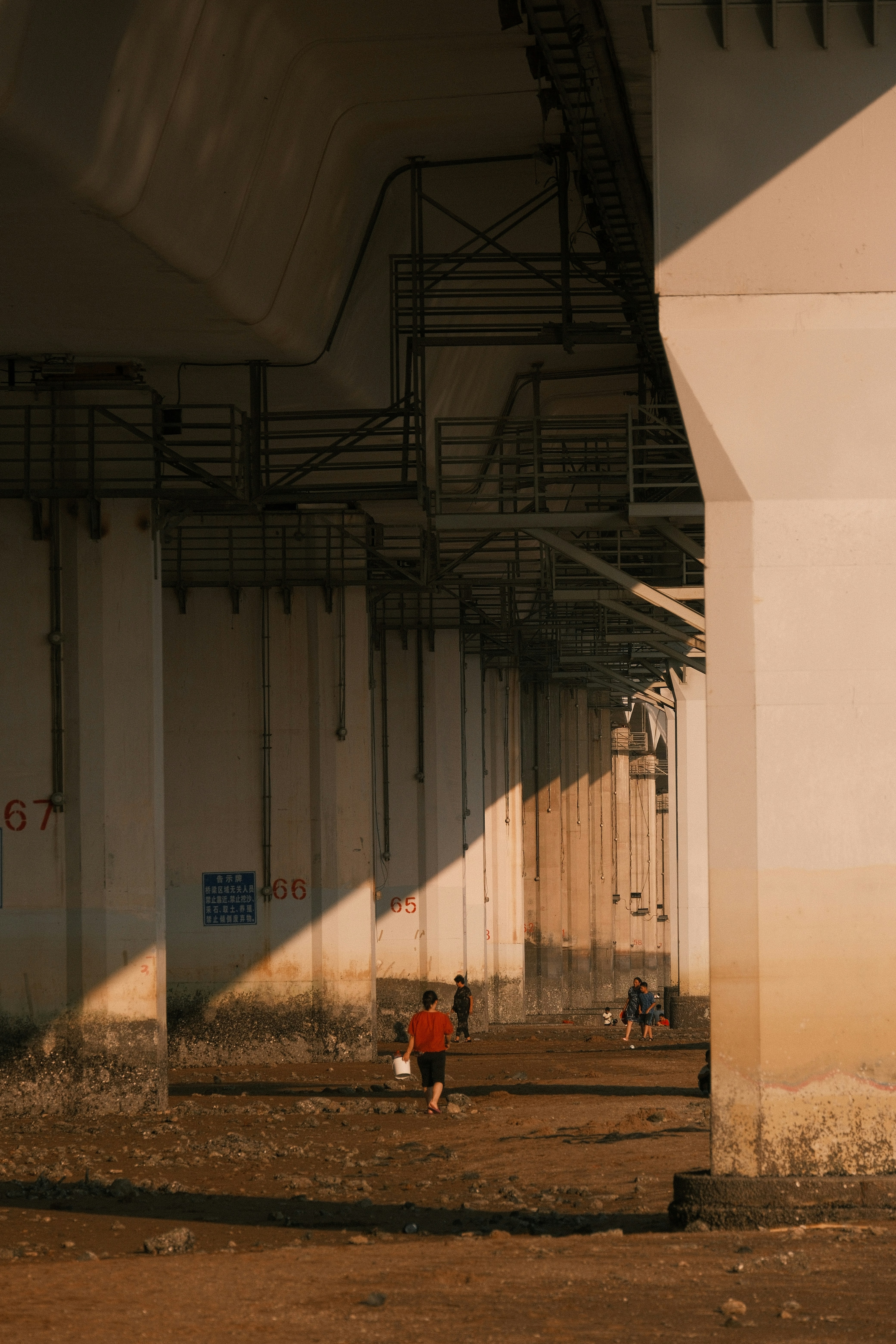 Shadowed Columns and a Walkway of Light Under Concrete Beams