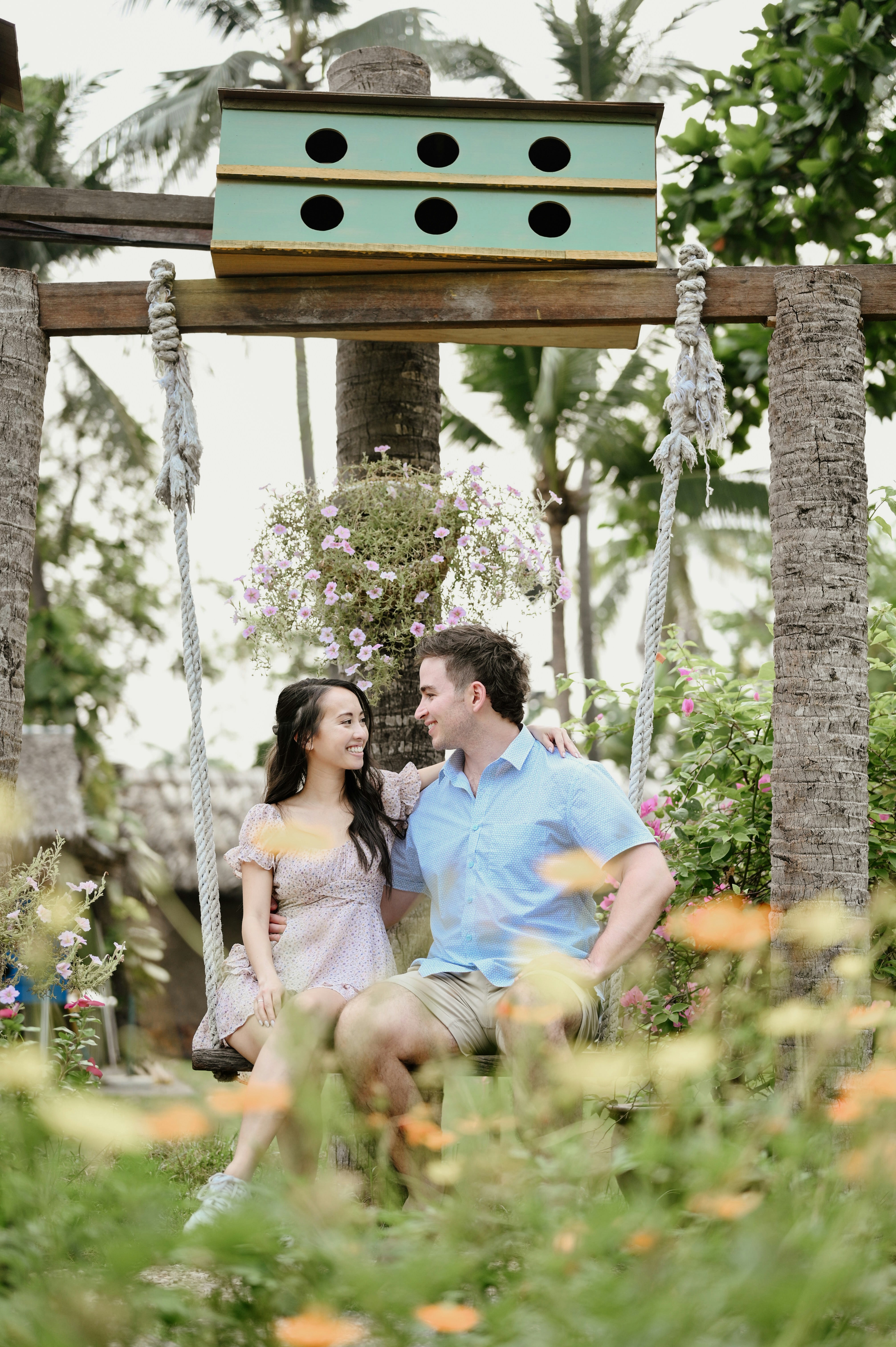 Swinging Moment: A Quiet Conversation Under Tropical Flowers