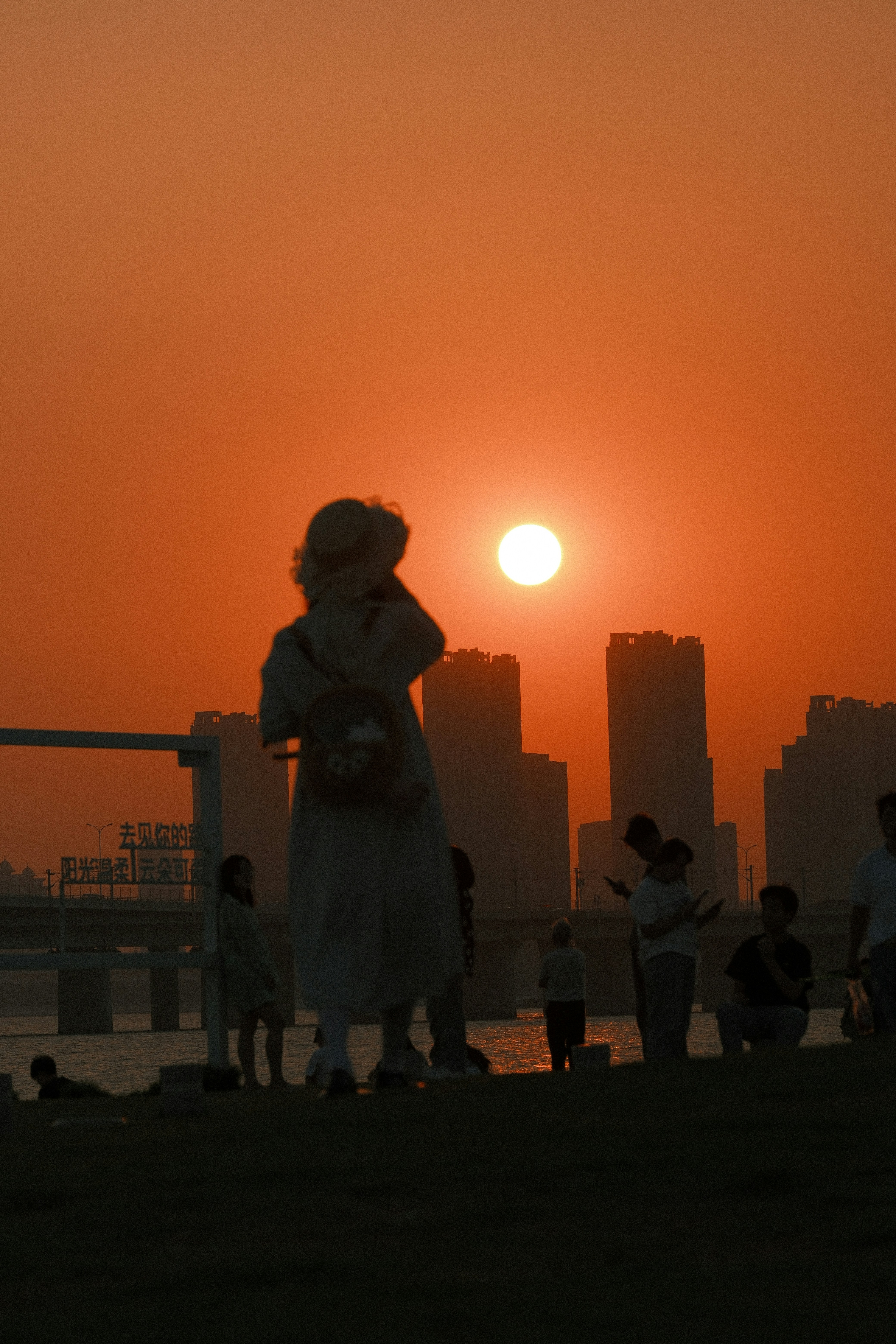 Sunset Silhouette: A Quiet Gathering by the Waterfront
