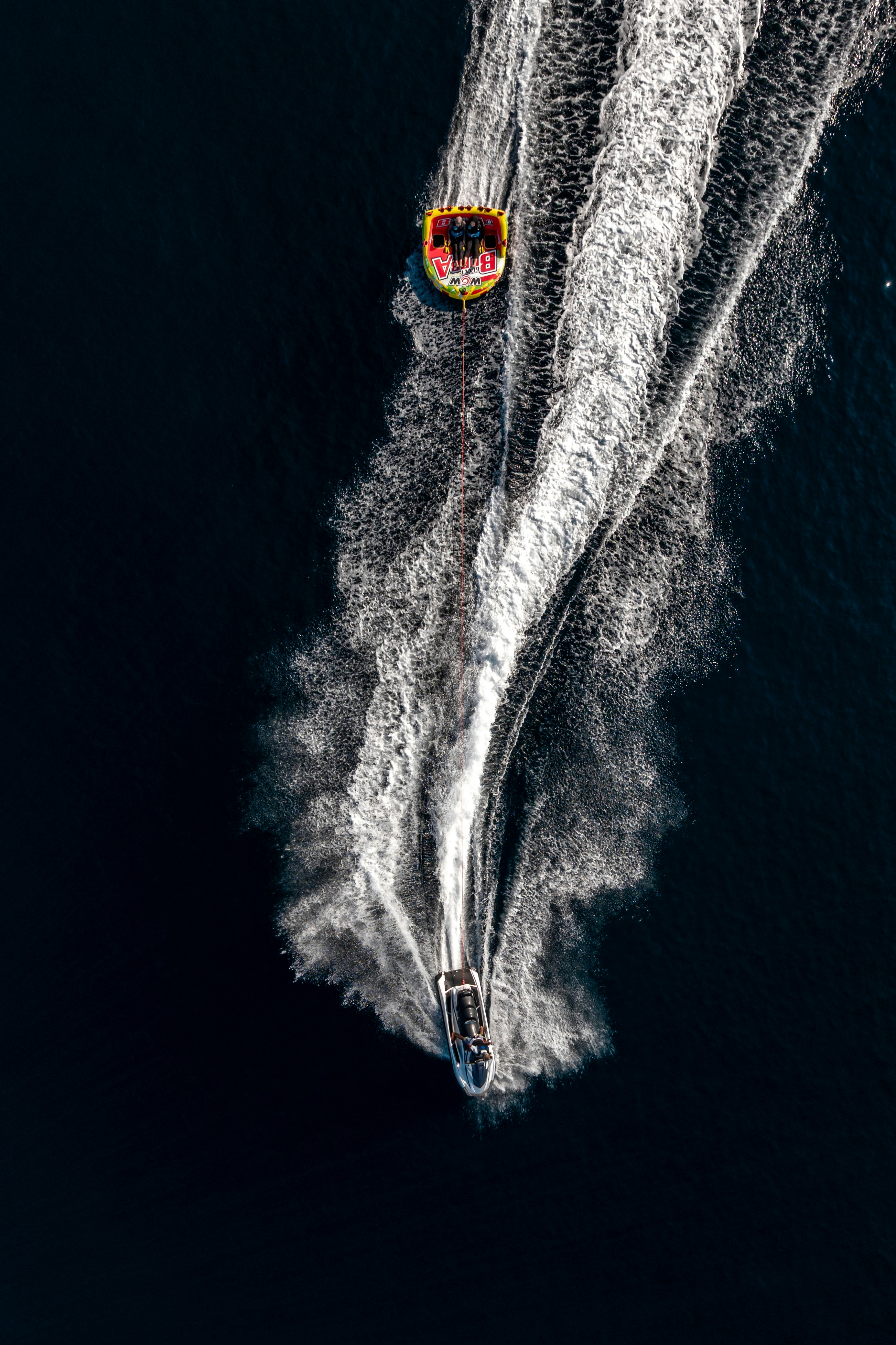 Twin Wake: Aerial Dance of Boat and Jet Ski in Dark Blue Wake