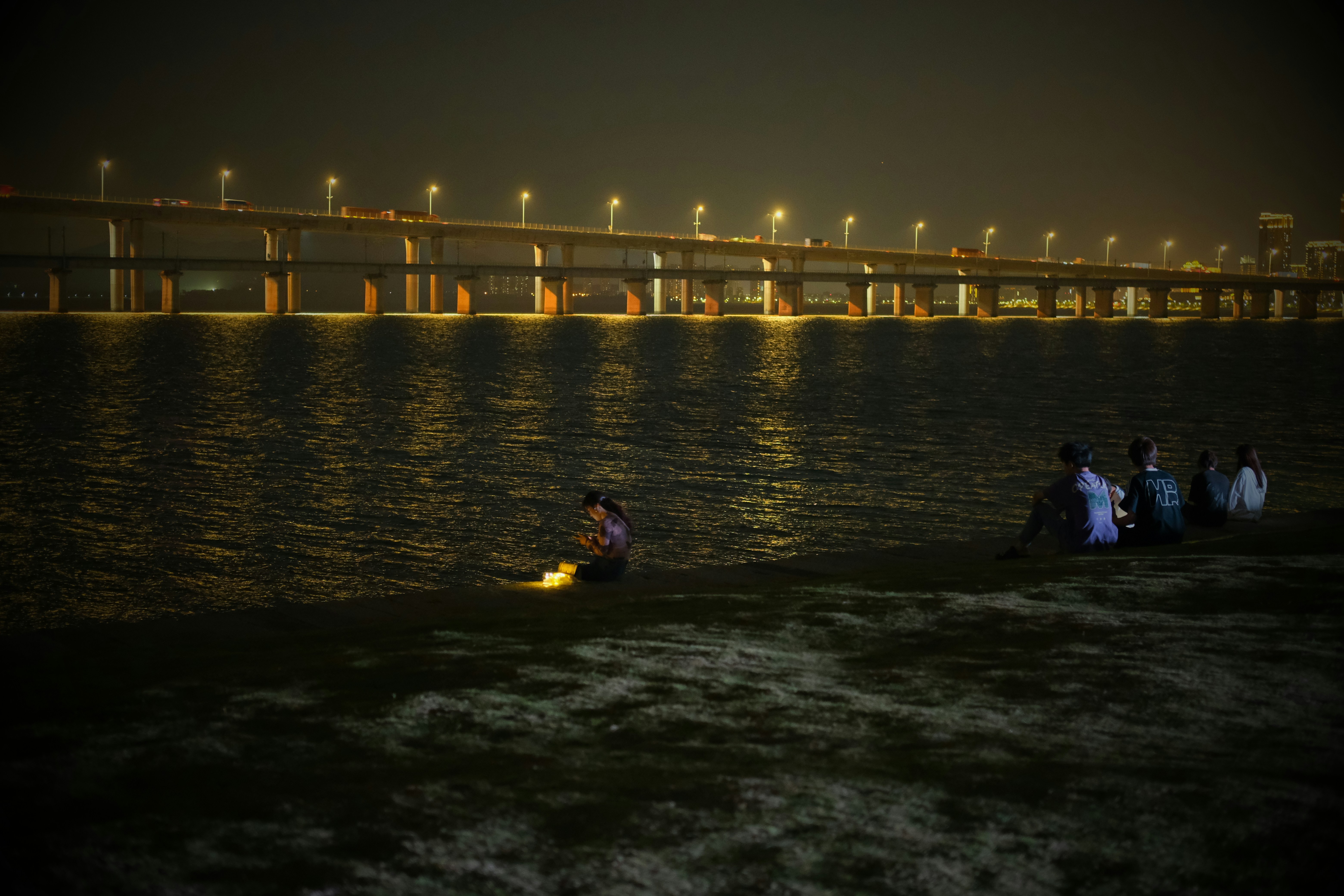 Quiet Ripples: Night Fishermen at the Illuminated Pier