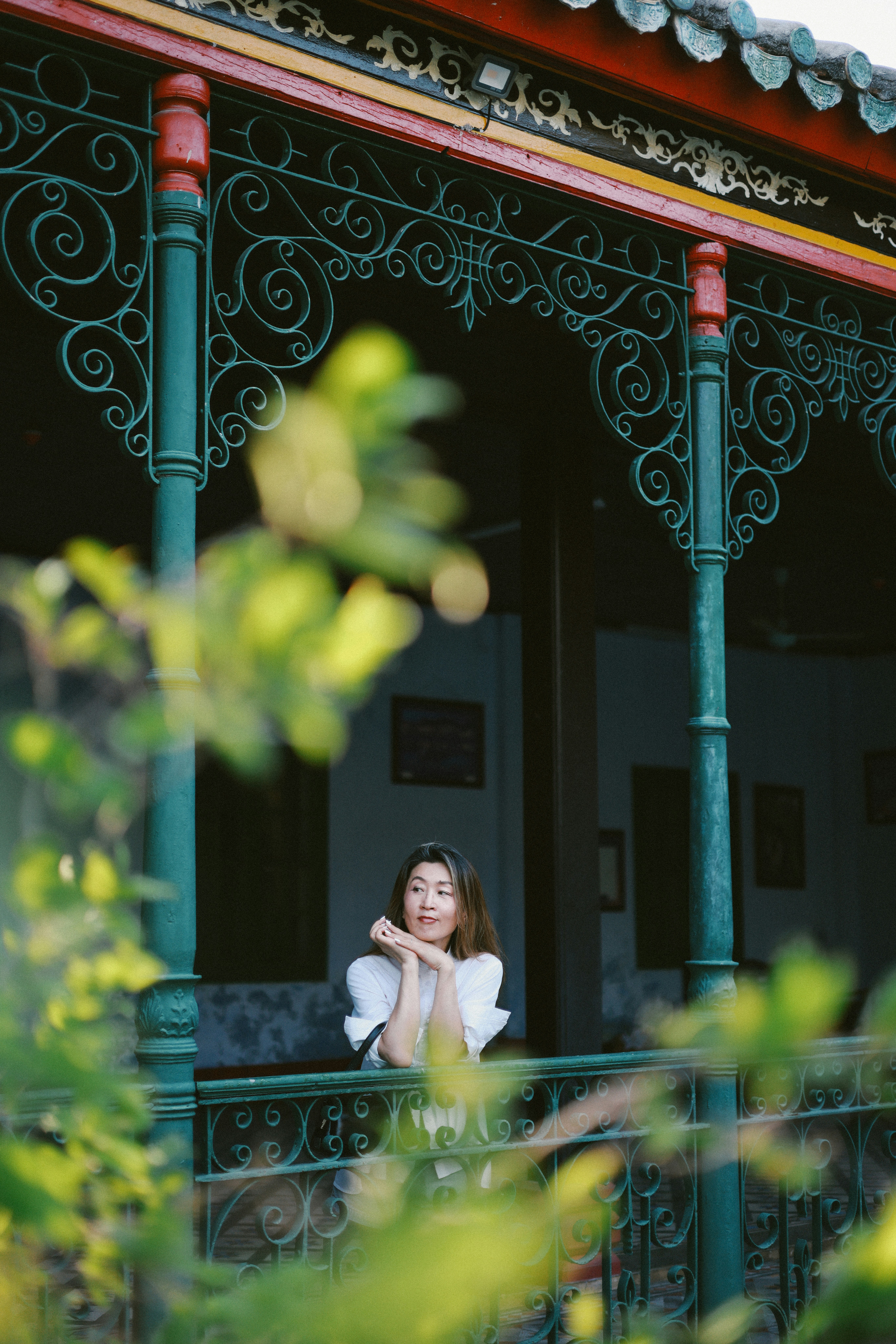 Portrait on a Pensive Balcony: A Quiet Moment Beneath Ornate Ironwork