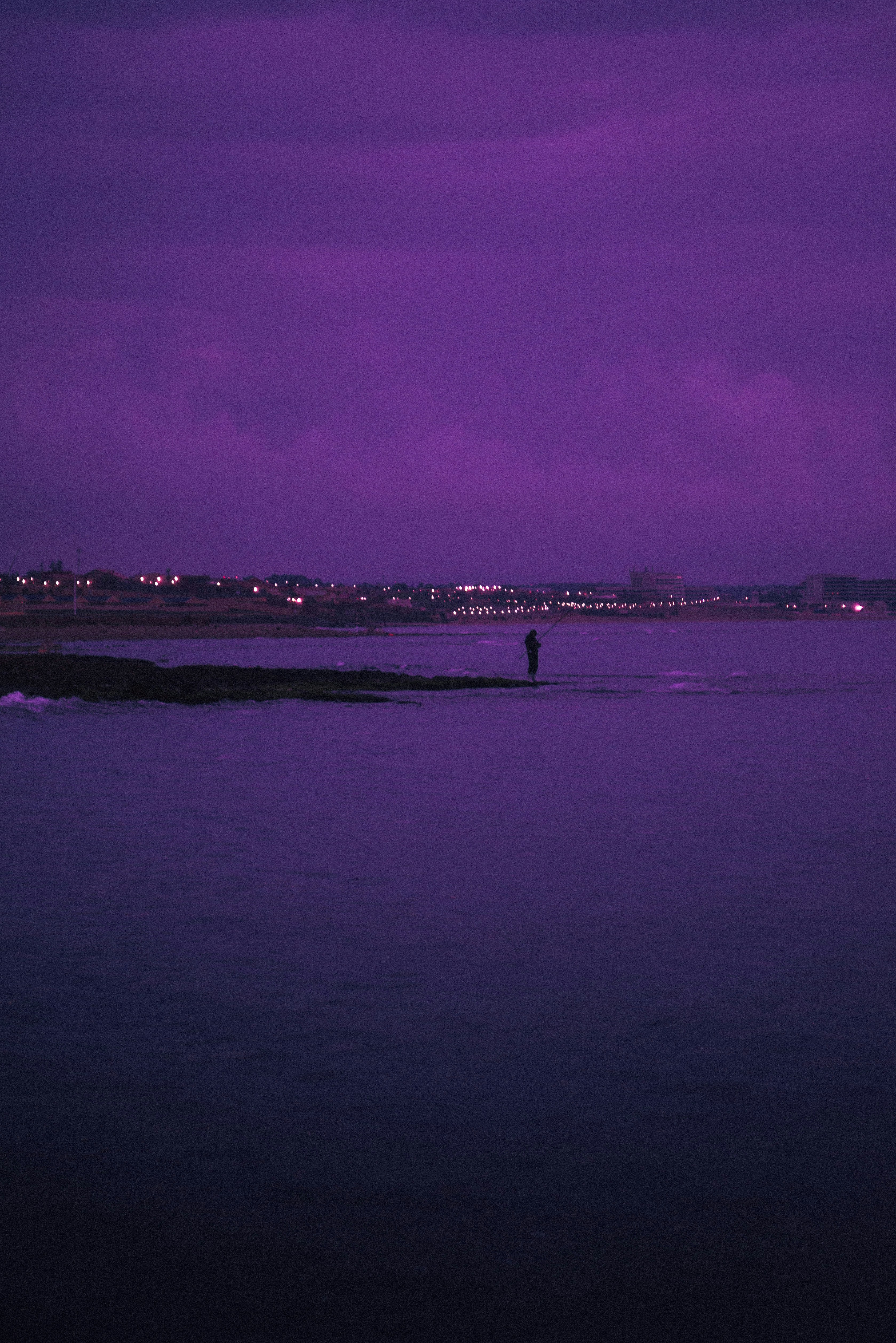 A lone figure stands by the water at dusk. photo – Free Sea Image on ...