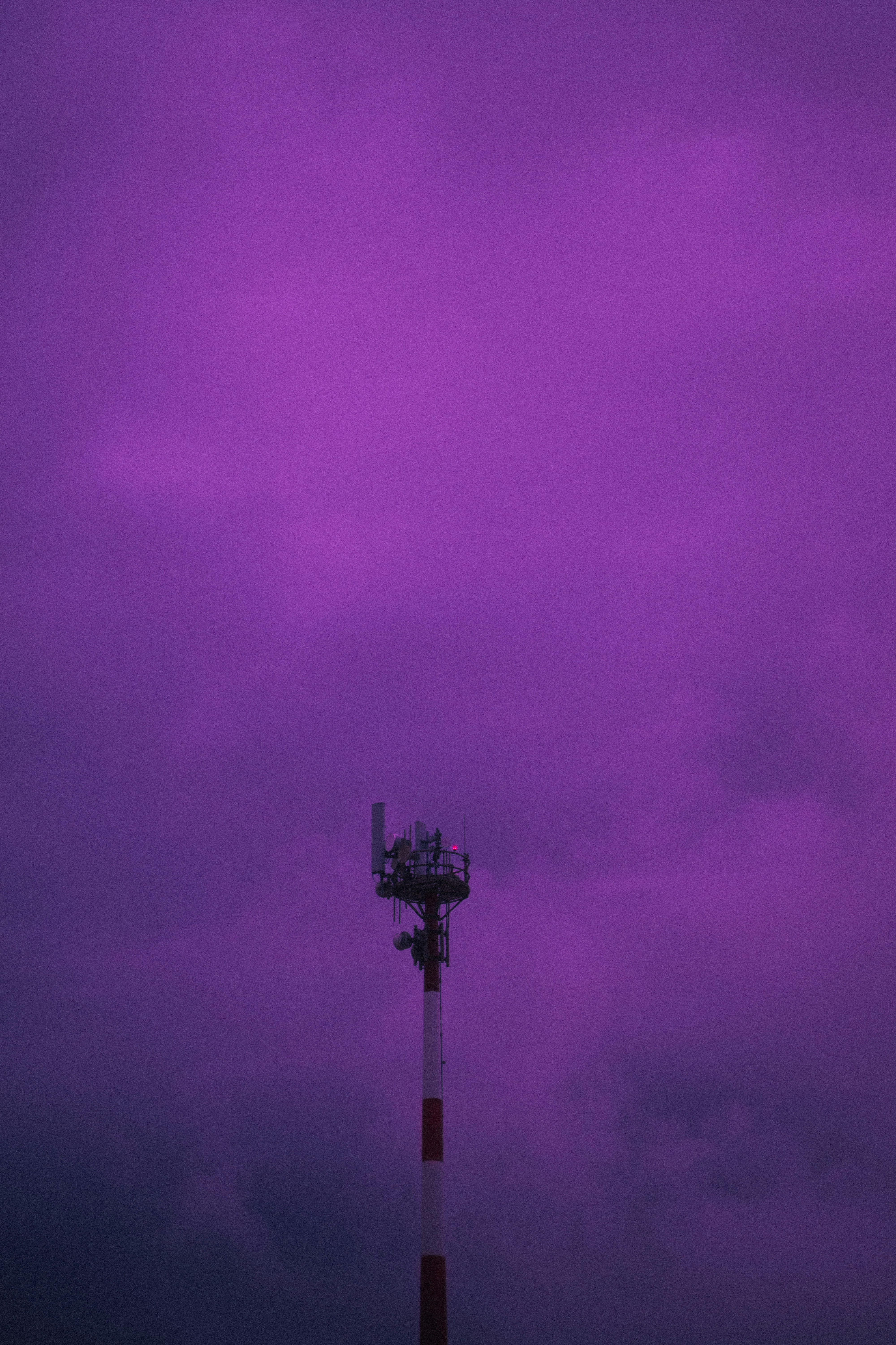 Purple Dawn Signal: A lone cellular tower piercing a violet sky