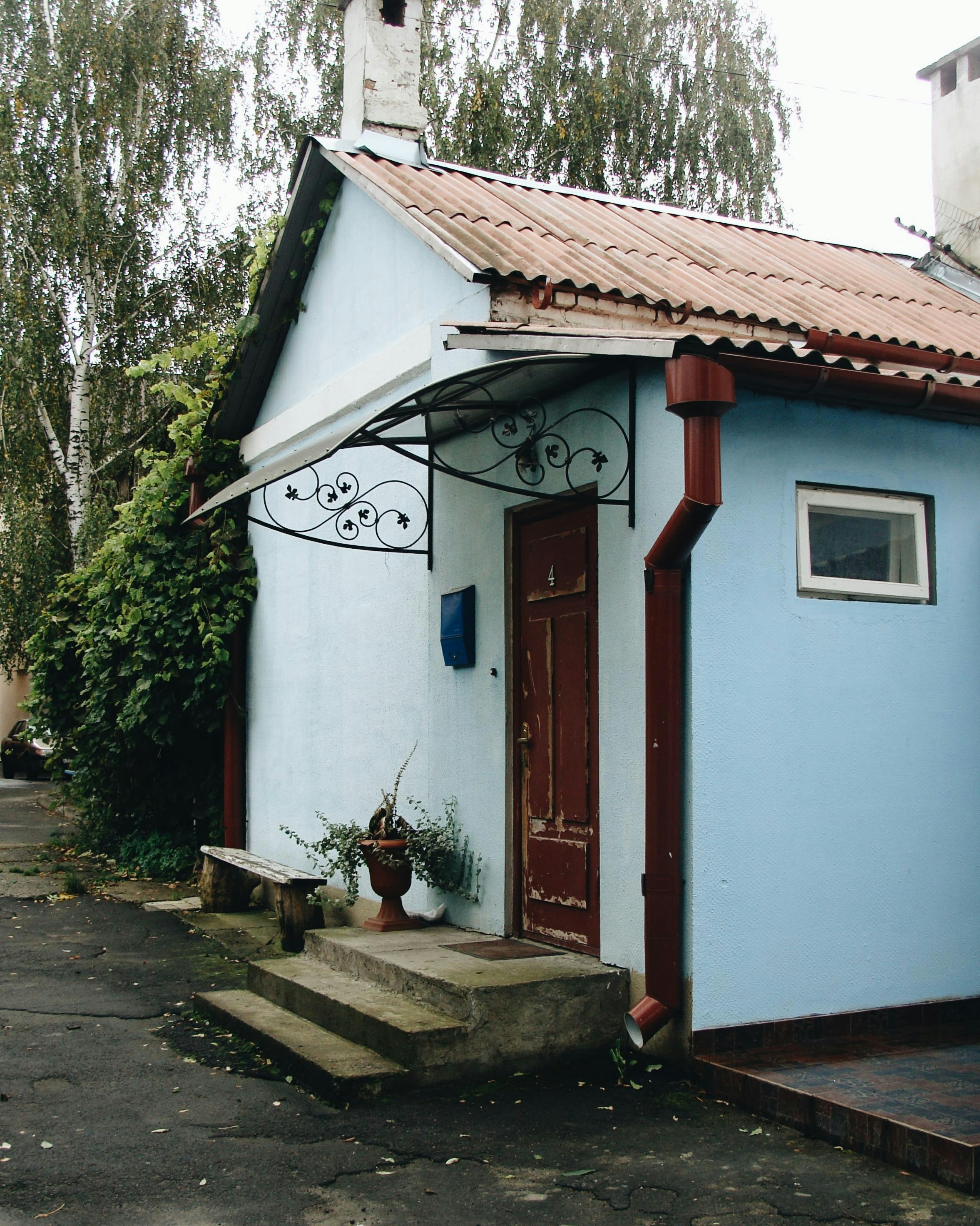 Blue Cottage at the Corner Stand with Ornate Entrance Arch