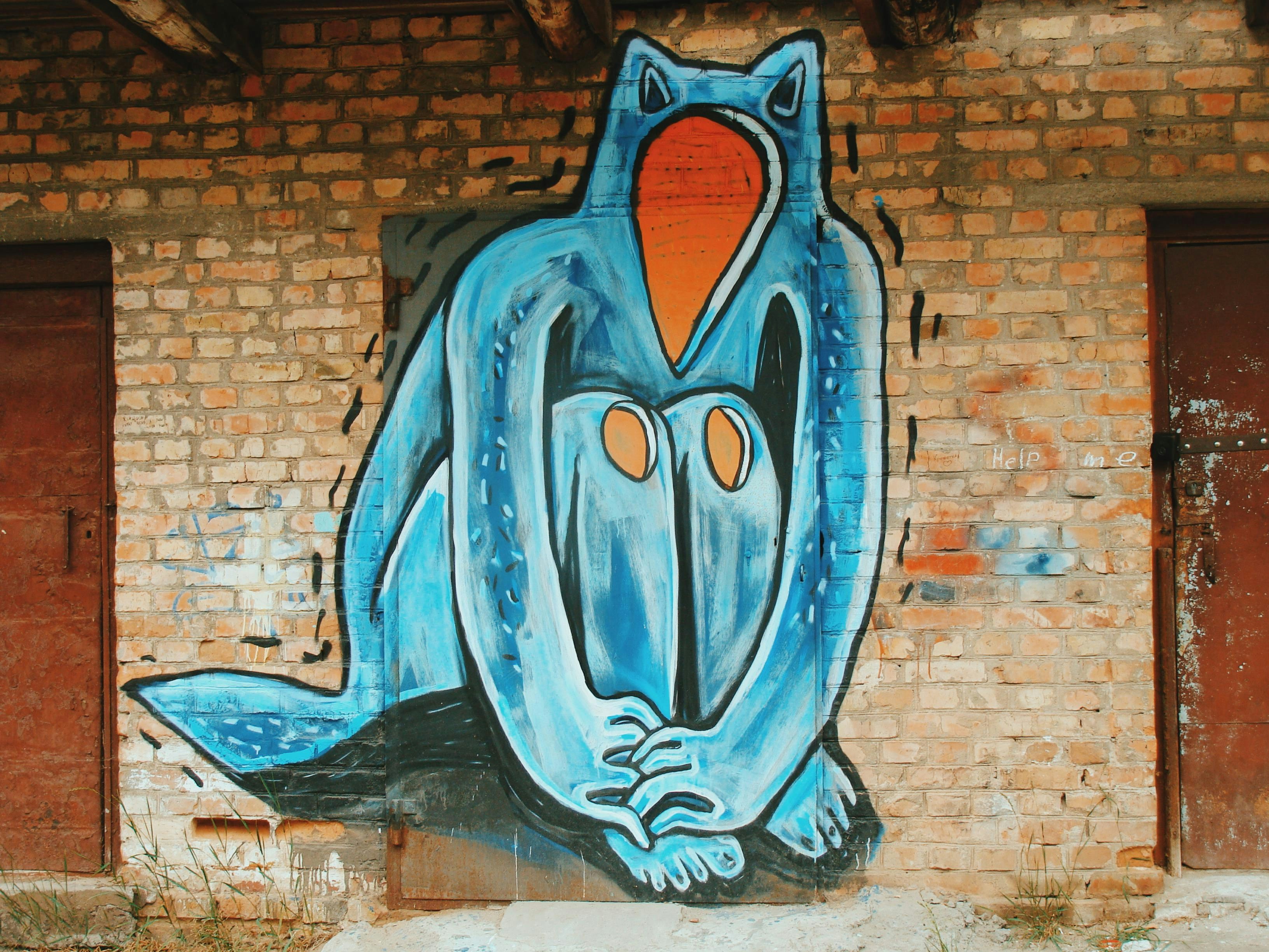 Blue Gargoyle Graffiti: A Quiet Figure Anchored Between Brick Doors