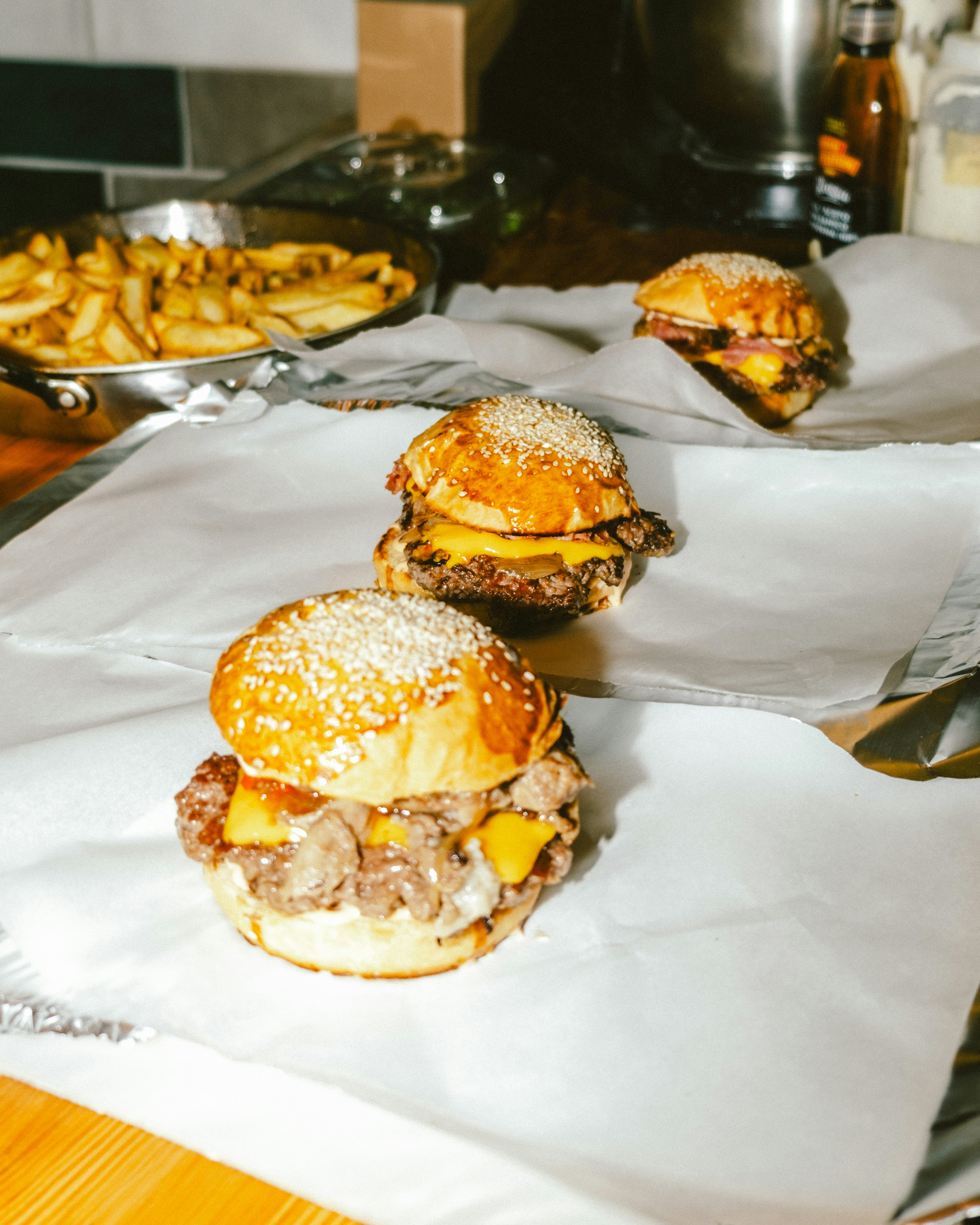 Three Gourmet Sliders marching toward a sunset of fries