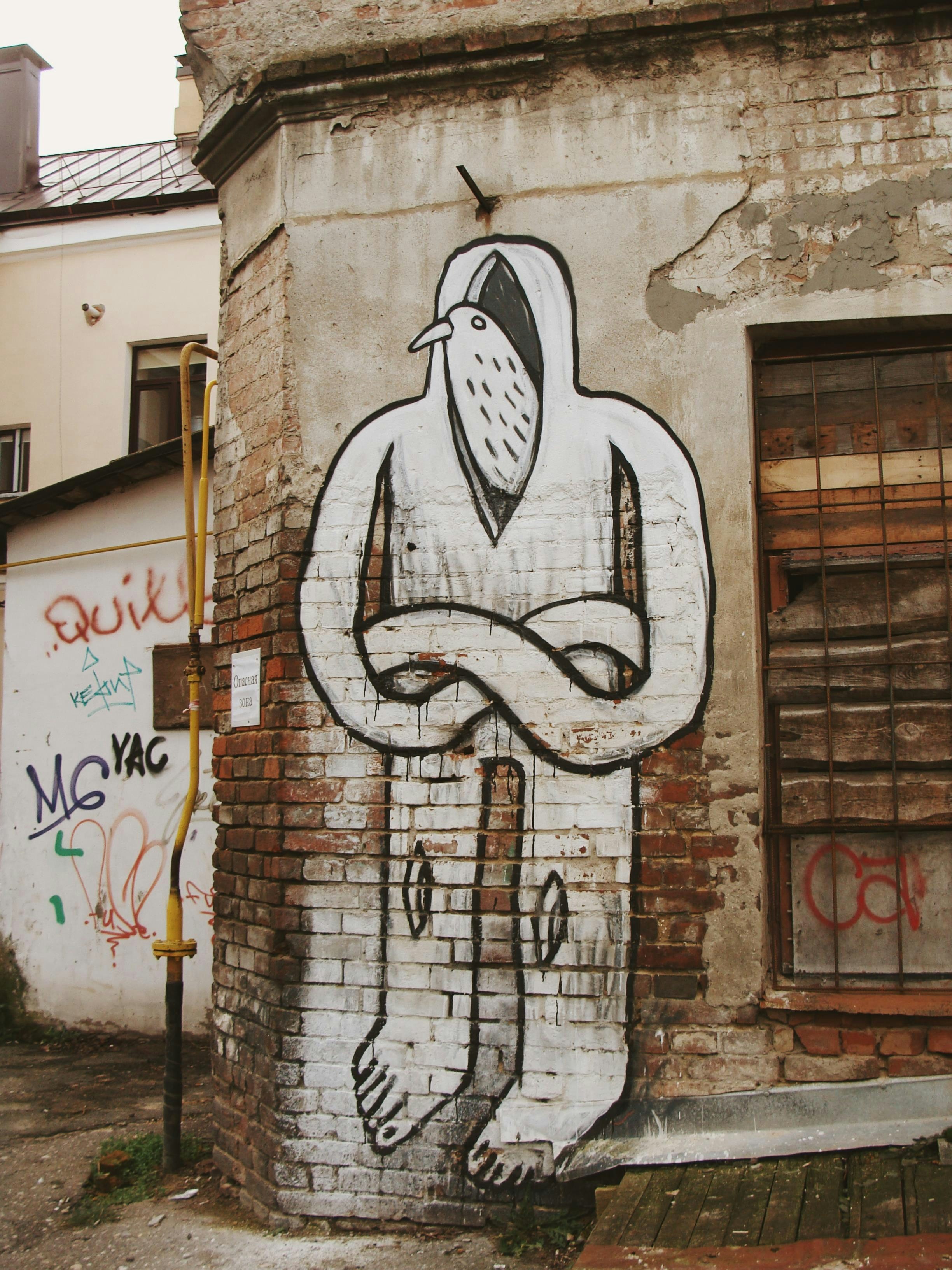 Graffiti Guardian: A Quiet Figure Stands Between Brick and Gate