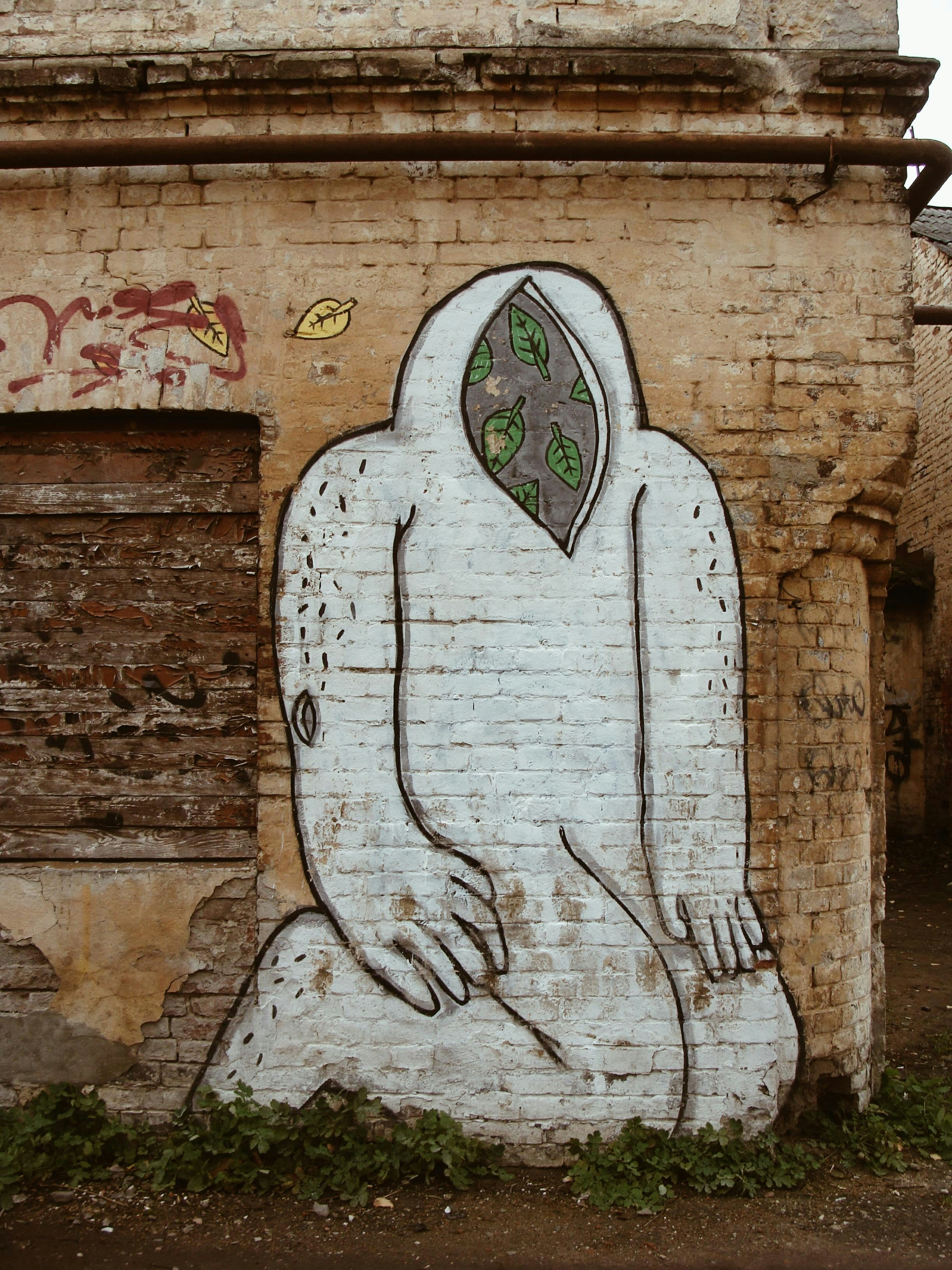 Graffiti Golem: Leafy Masked Figure Emerges from Brick Silence