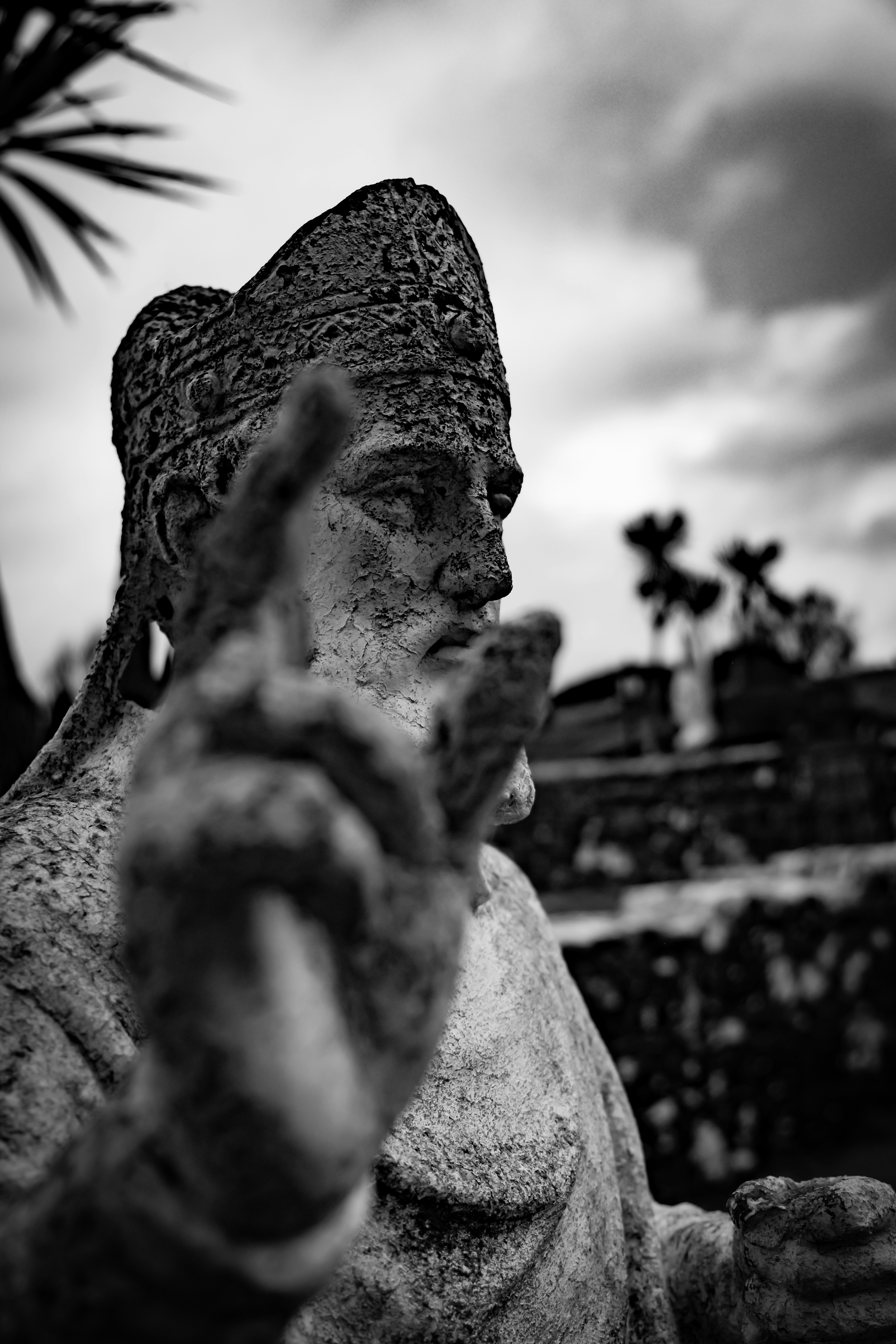 Stone Guardian in Focus: A Weathered Statue Reaching Toward the Sky
