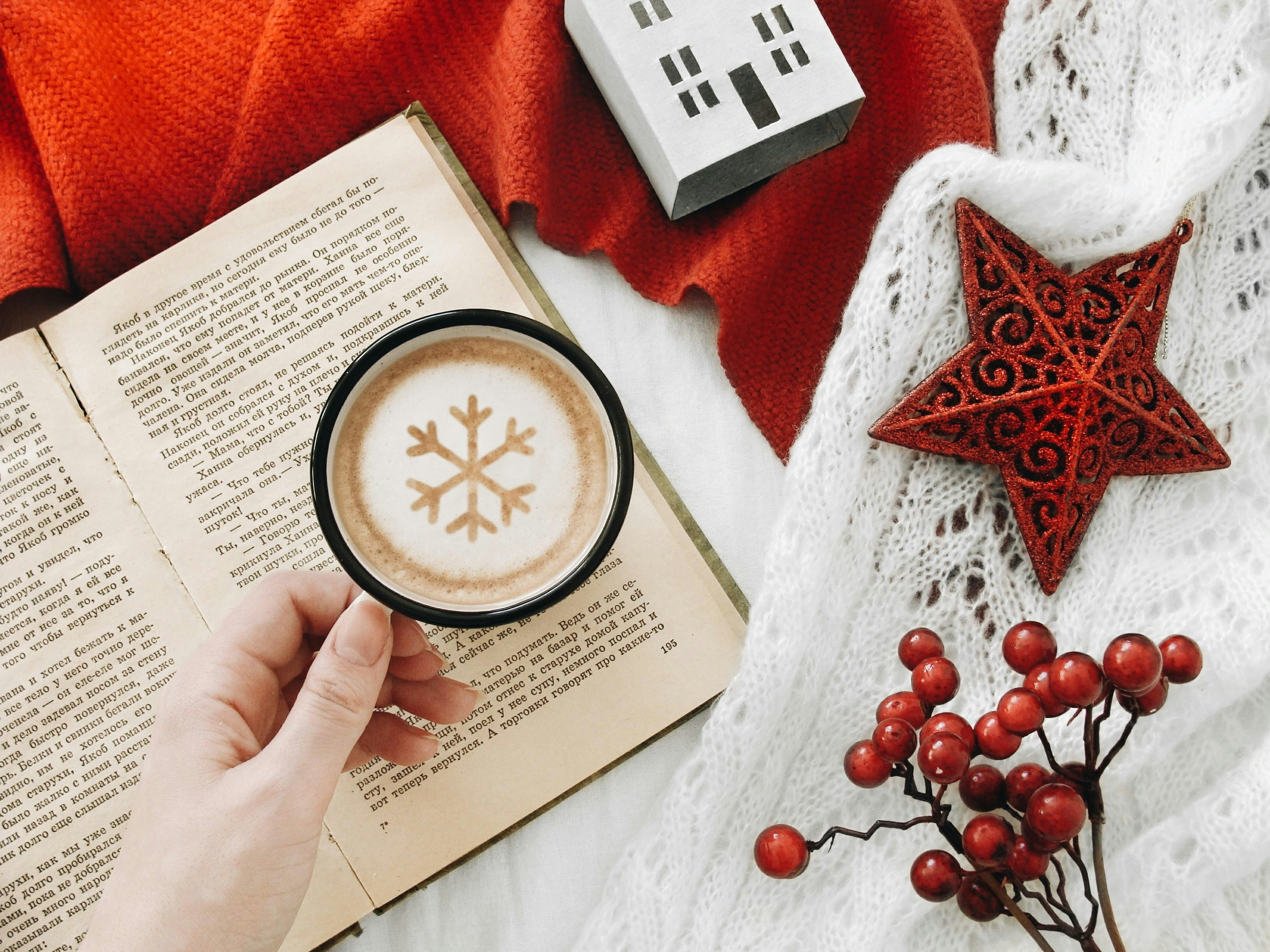 Cozy winter ritual: latte, book, and decorative ornaments