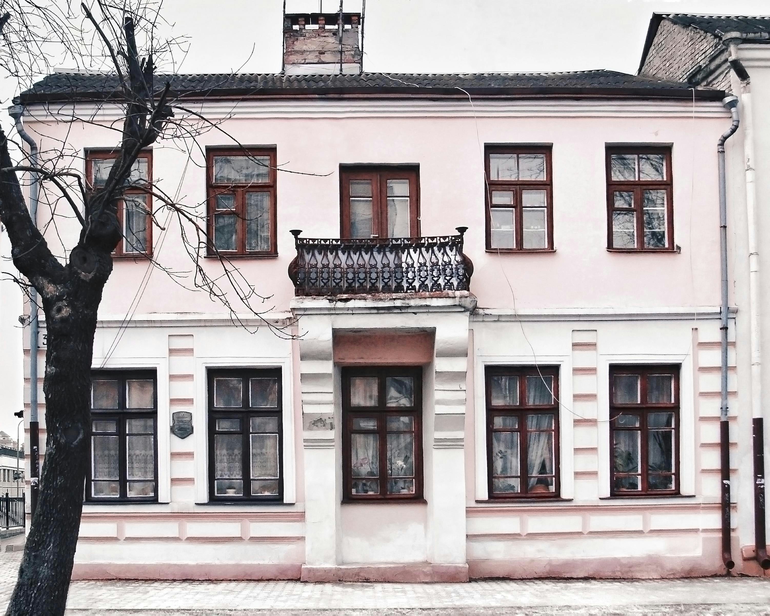 A pale pink building with dark windows and balcony. photo – Free Window ...