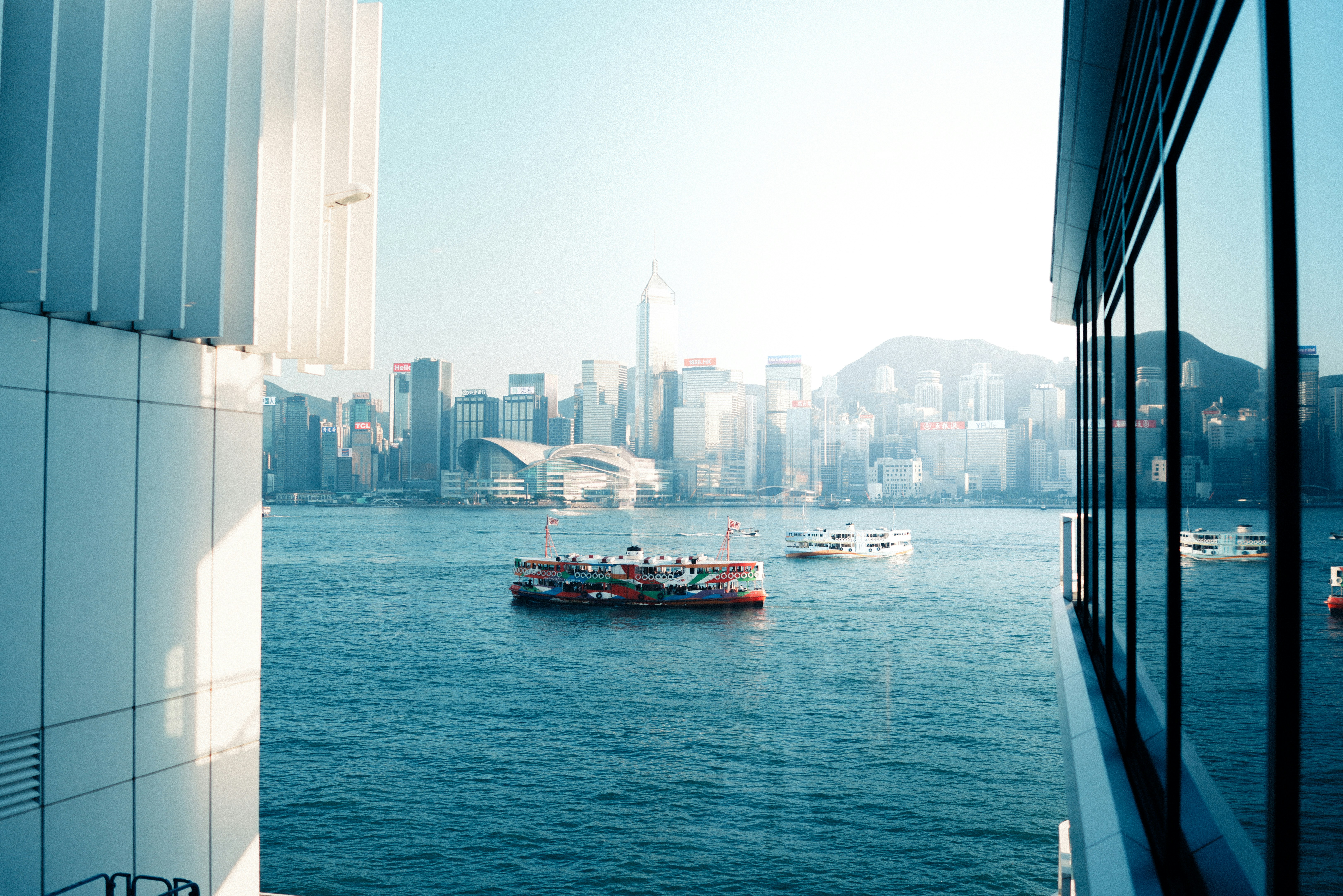 Ferries cross a bay with city skyline background
