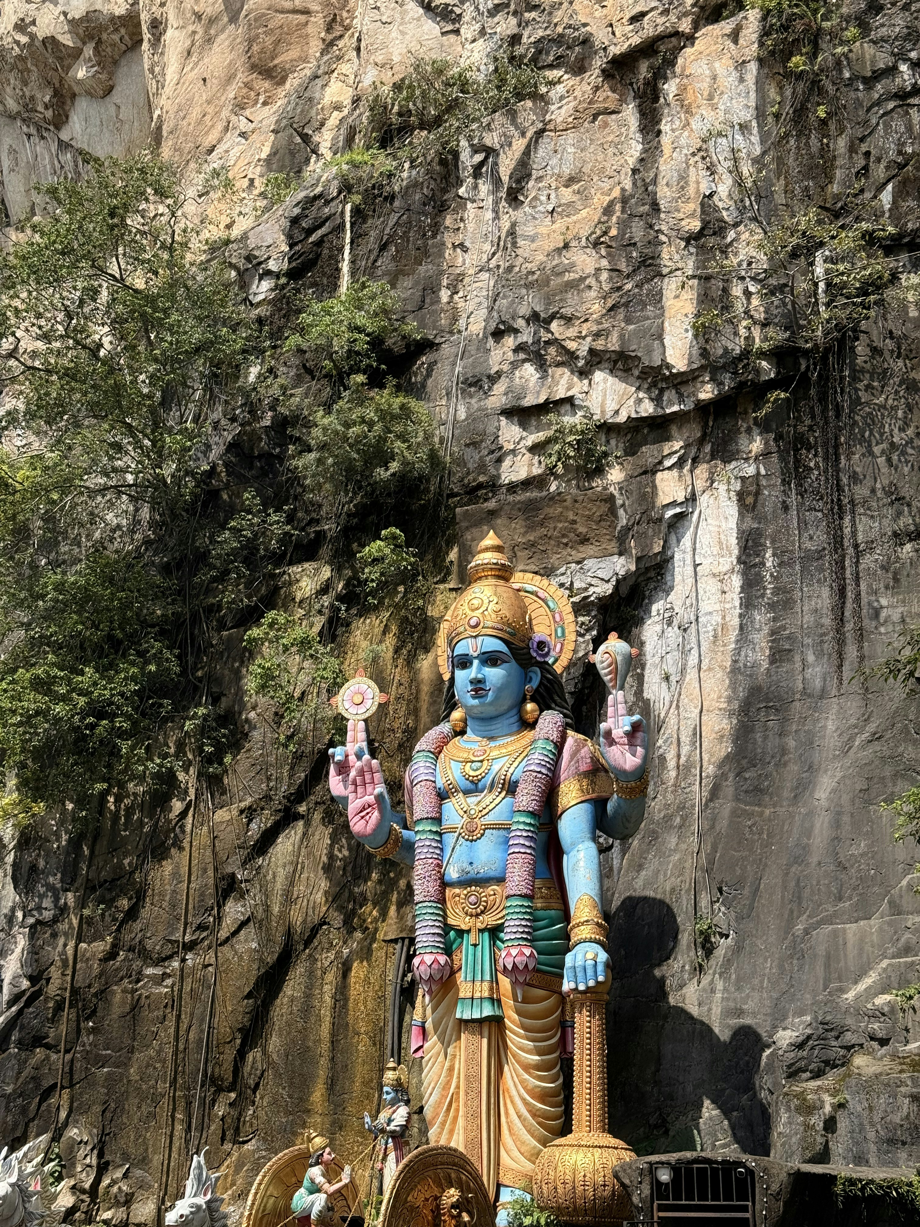 Azure Deity Rising from the Rock: A Bespoke Hindu Statue Amid Cliff Habitat
