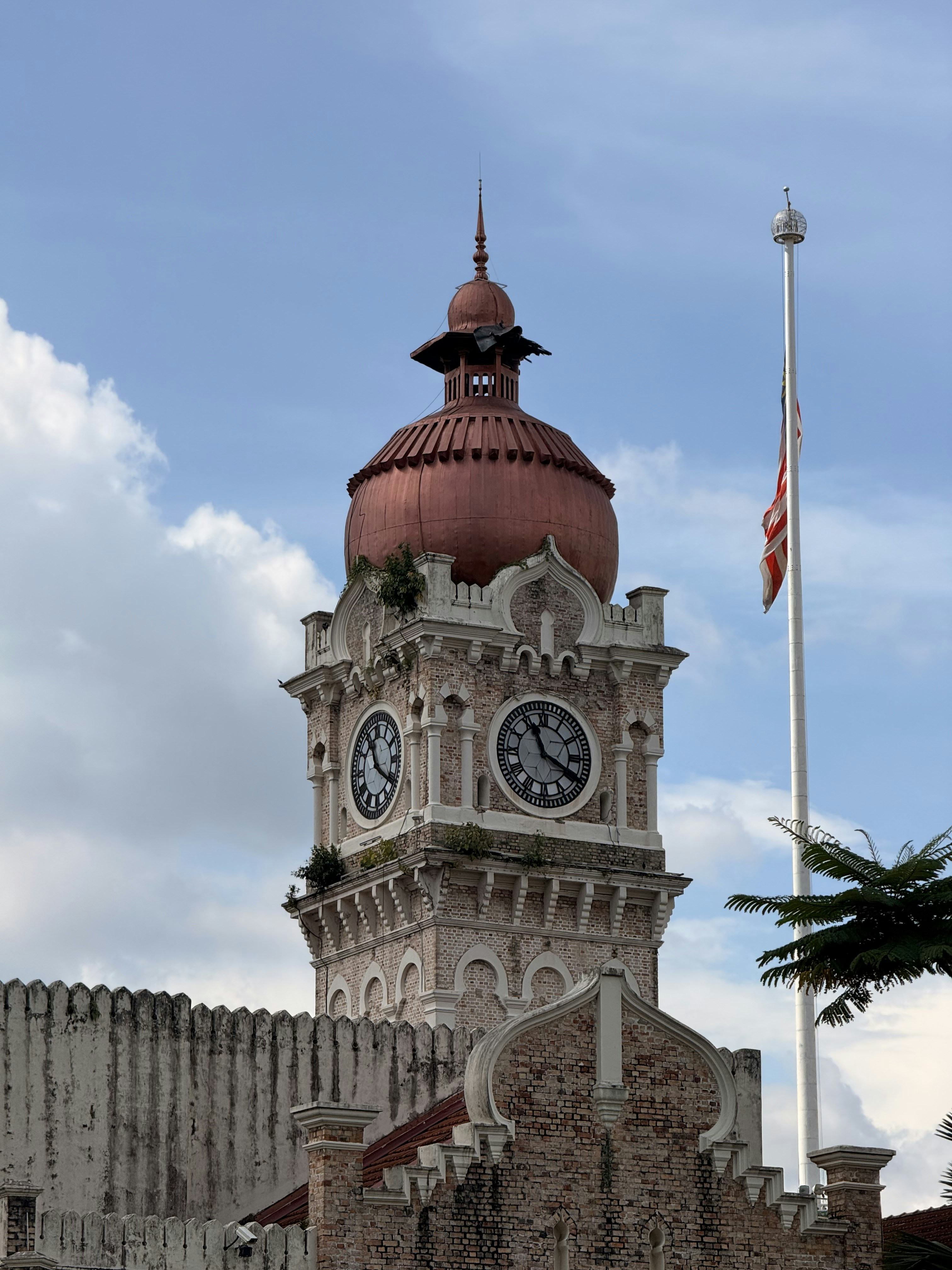 Clock Tower Crowned with a Red Dome Rises Against a Clear Sky
