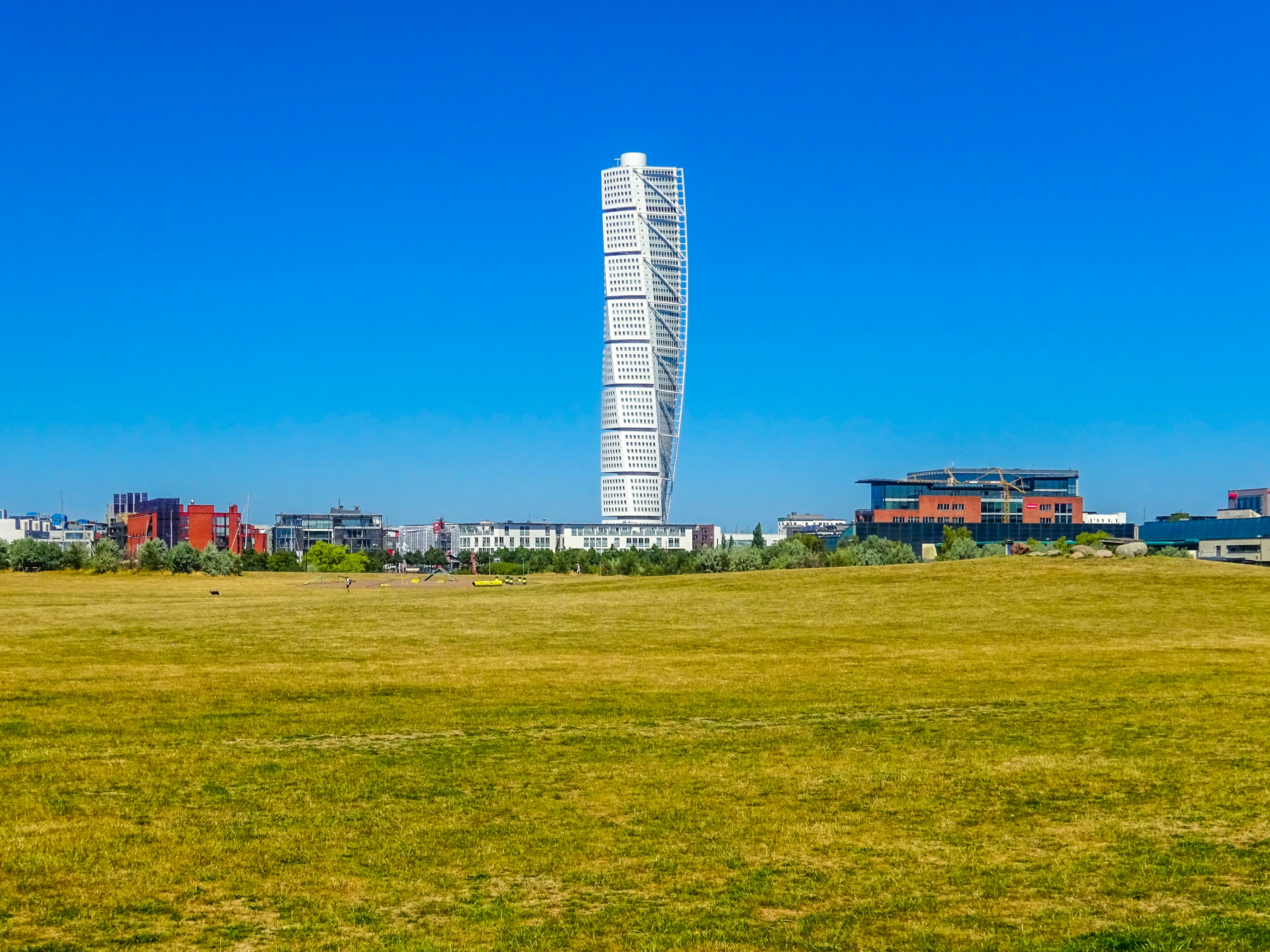 Modern twisted skyscraper against a clear blue sky.