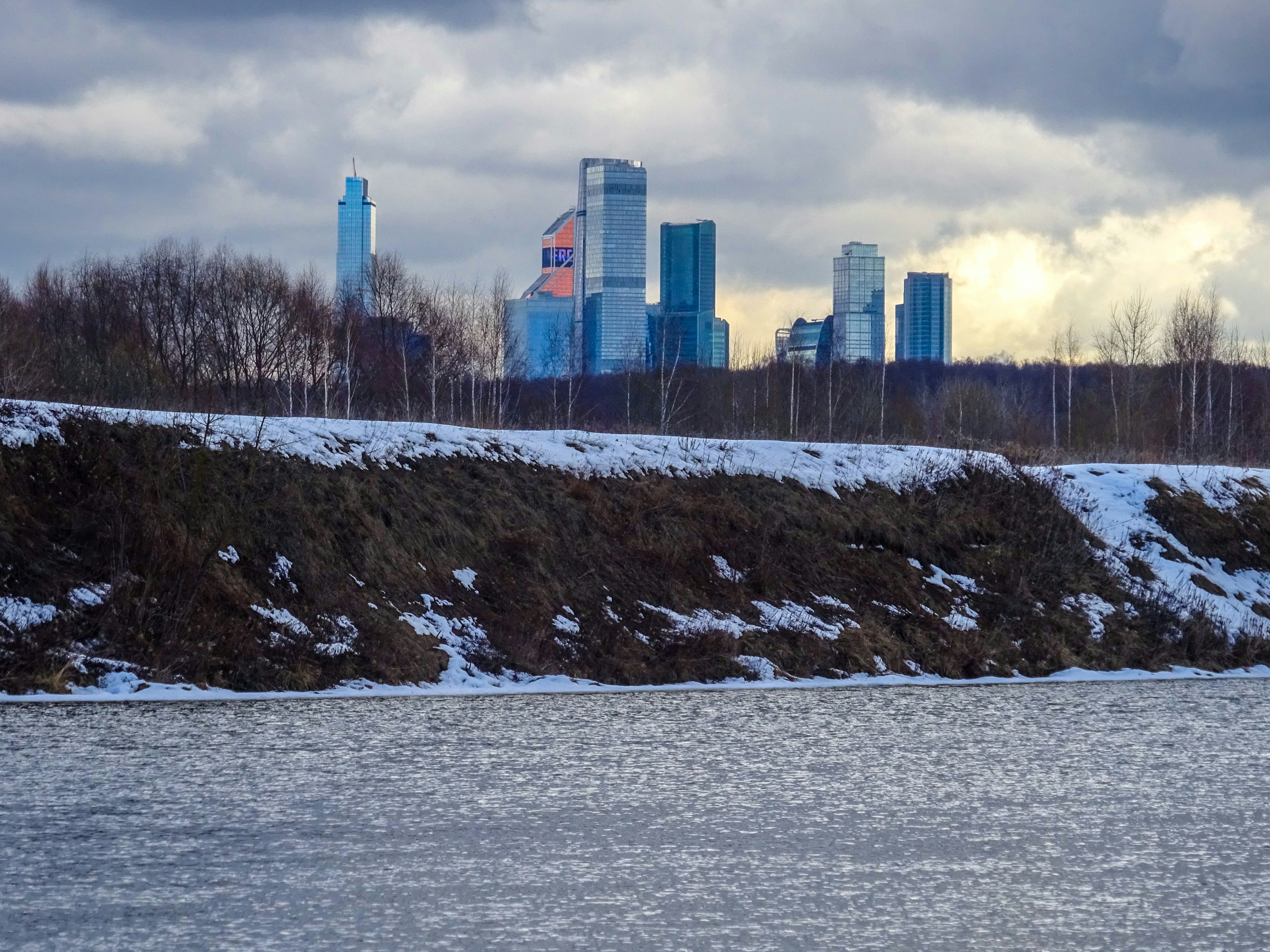 City Silhouette Rising Over Snow-Challenged Shore