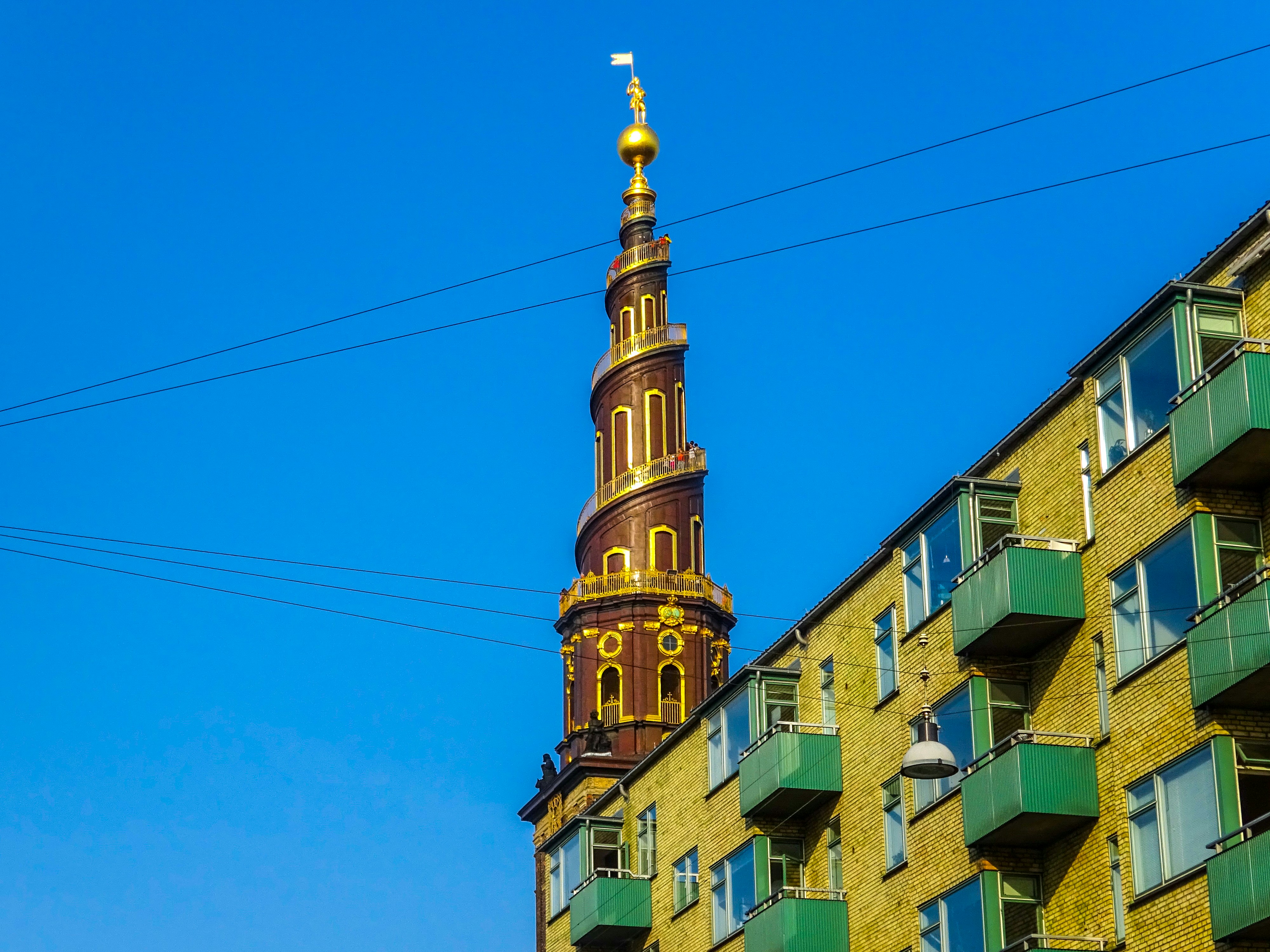 Spire Rising Above Green-Carpeted Balconies