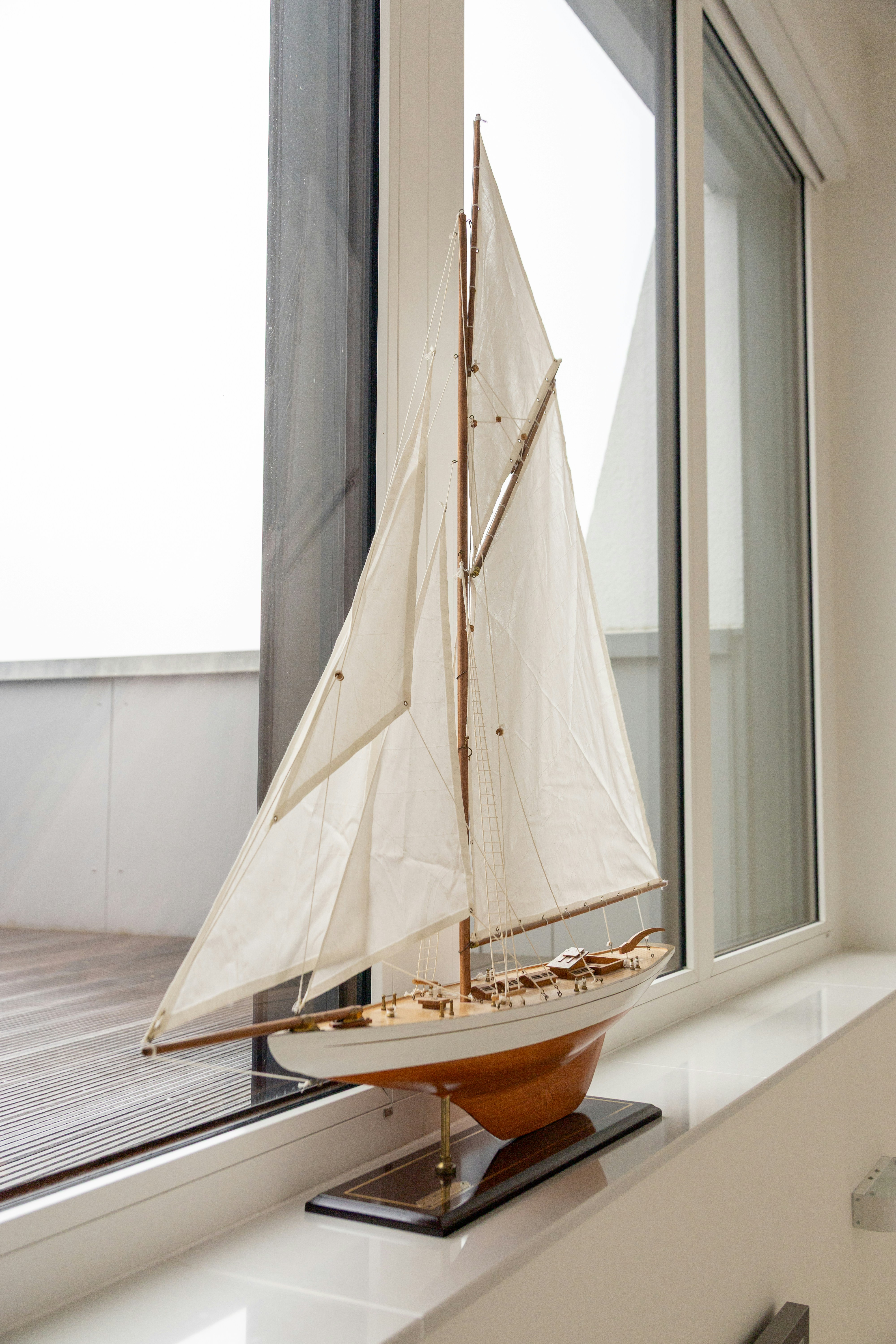 Maritime Miniature: A Sailboat Model Casting Shadow by Window Light
