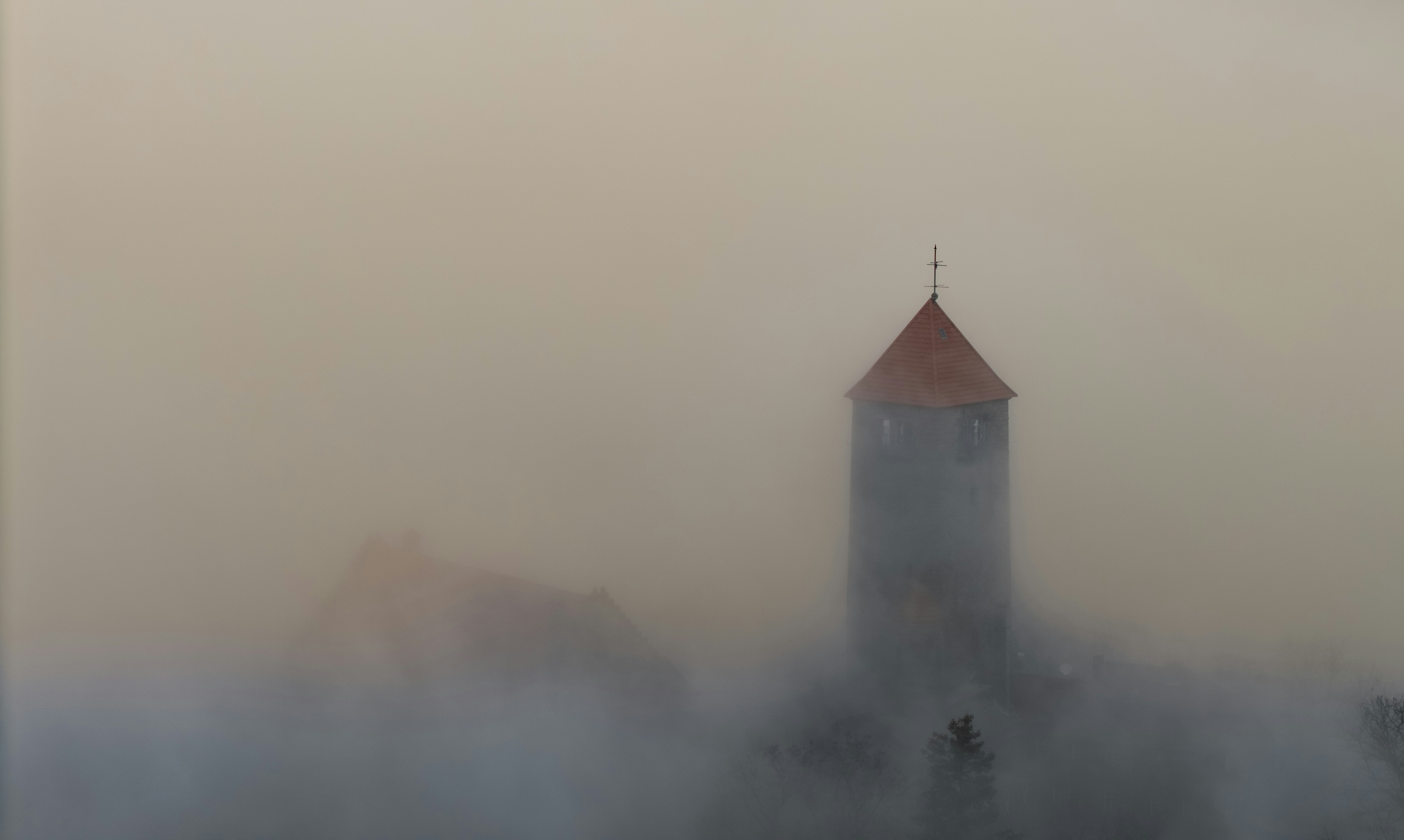 Tower Rising Through the Mist: A Solitary Keep in Hazy Dawn