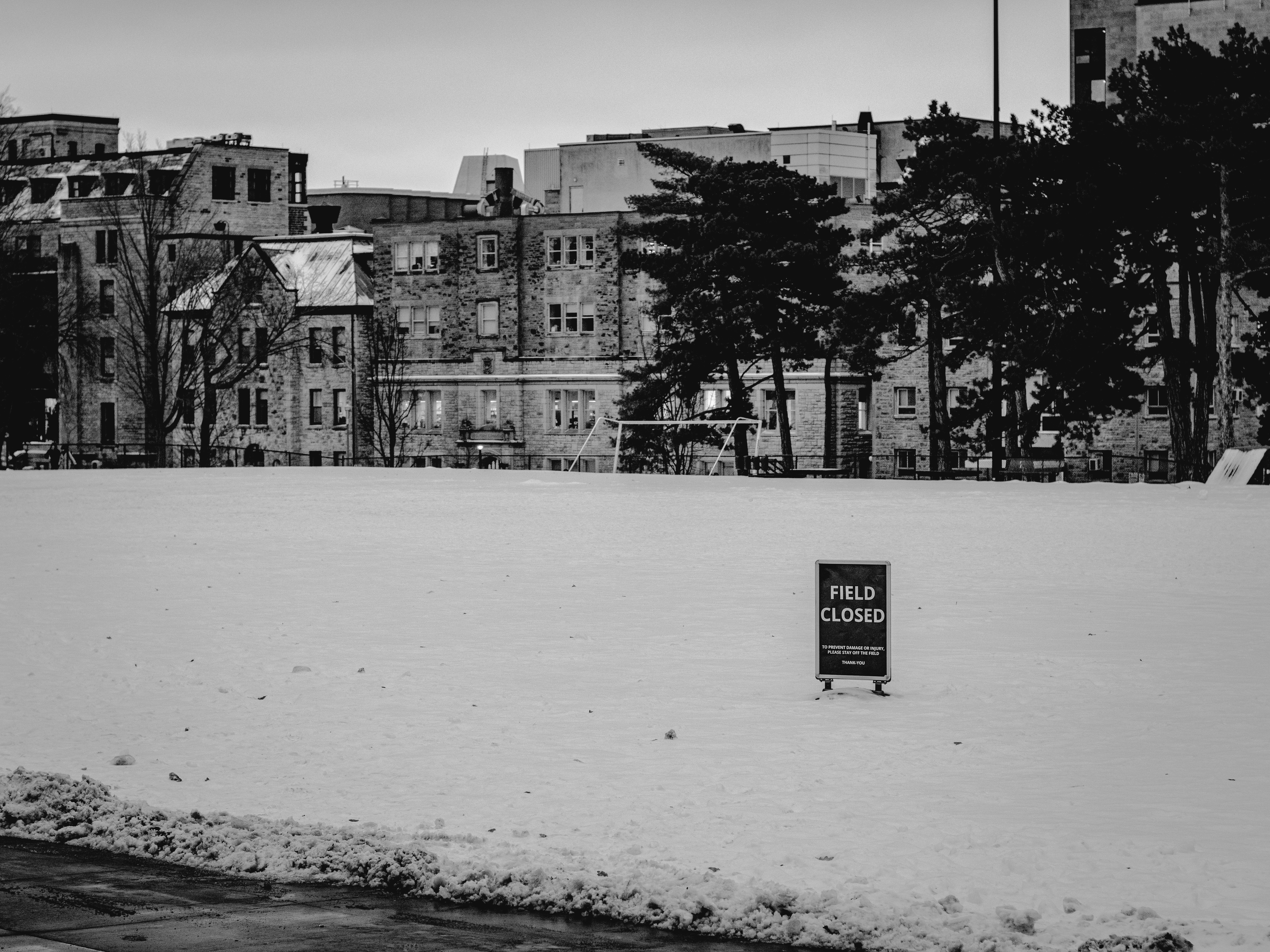 Snowy campus frontier under a looming sign